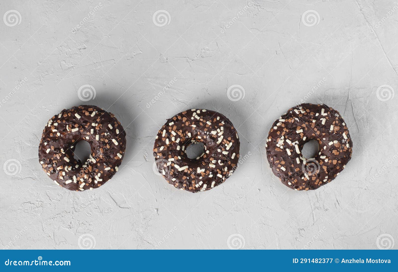 Three Donuts Covered with Chocolate Glaze on Light Gray Background, Top ...