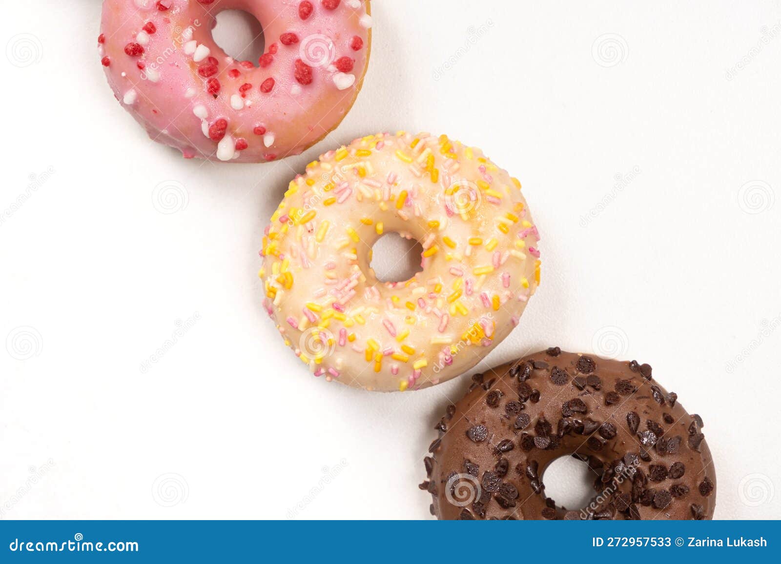 Three Donuts in a Row - White, Pink and Chocolate on a White Background ...