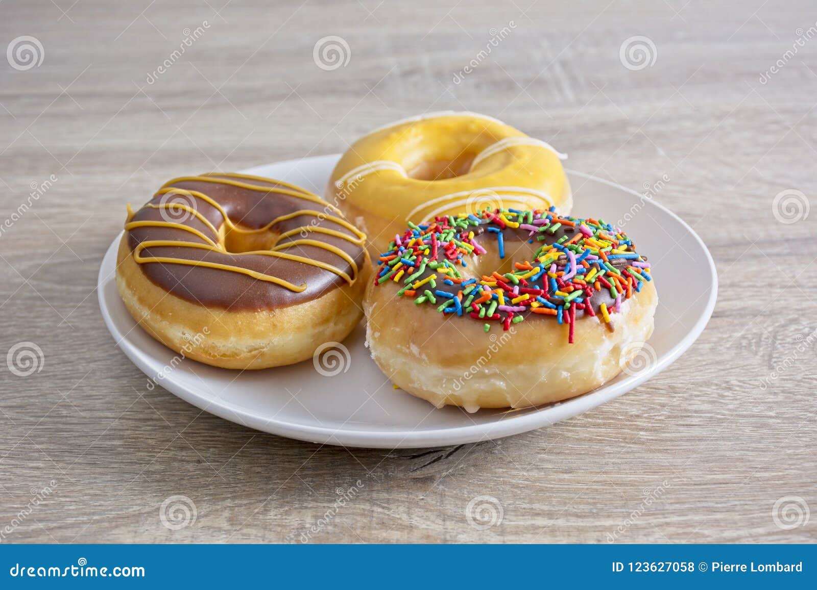 Three Doughnuts on White Plate Stock Photo - Image of plate, iced ...
