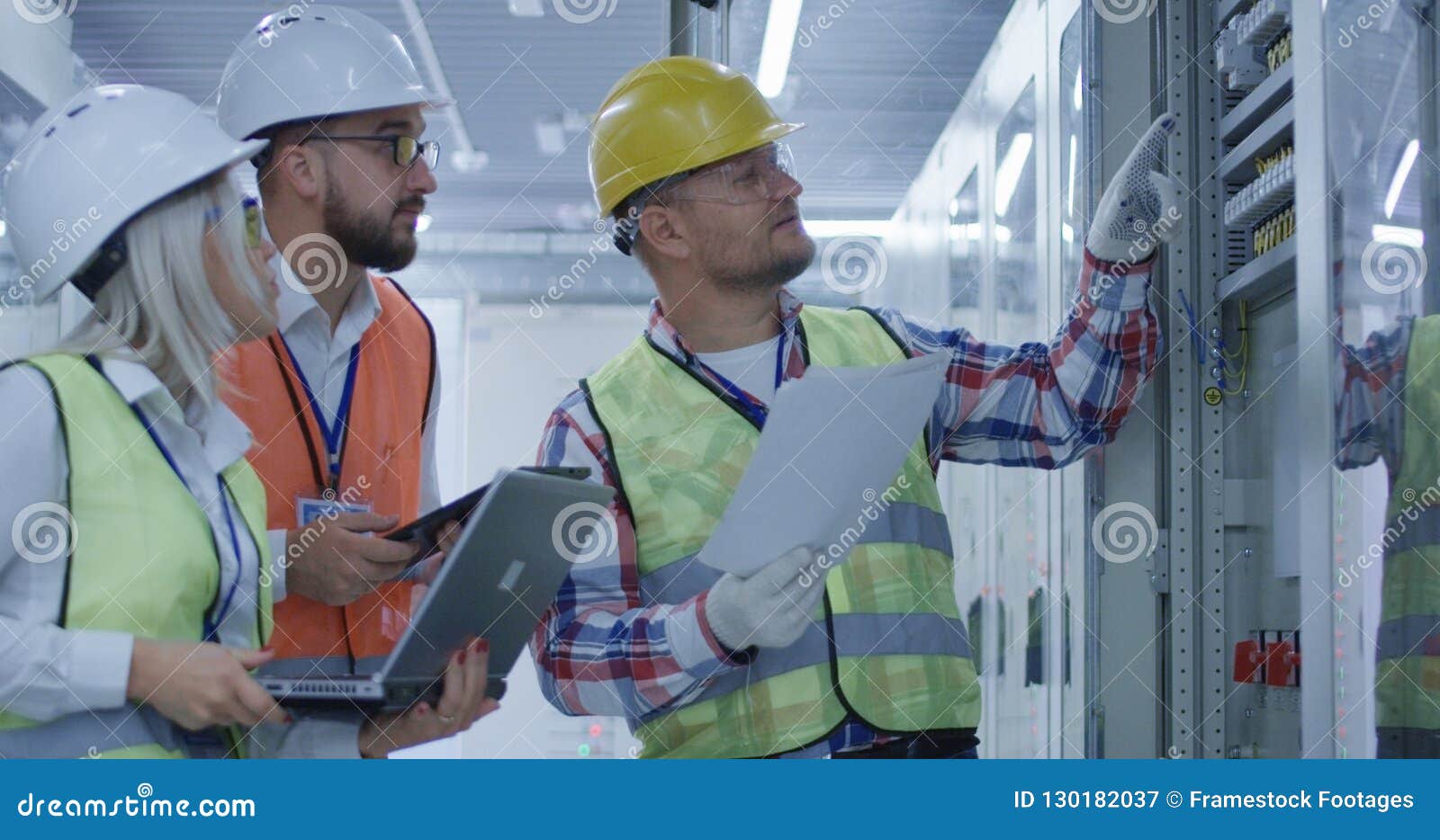 Three Electrical Workers Reviewing Documents Stock Image - Image of ...