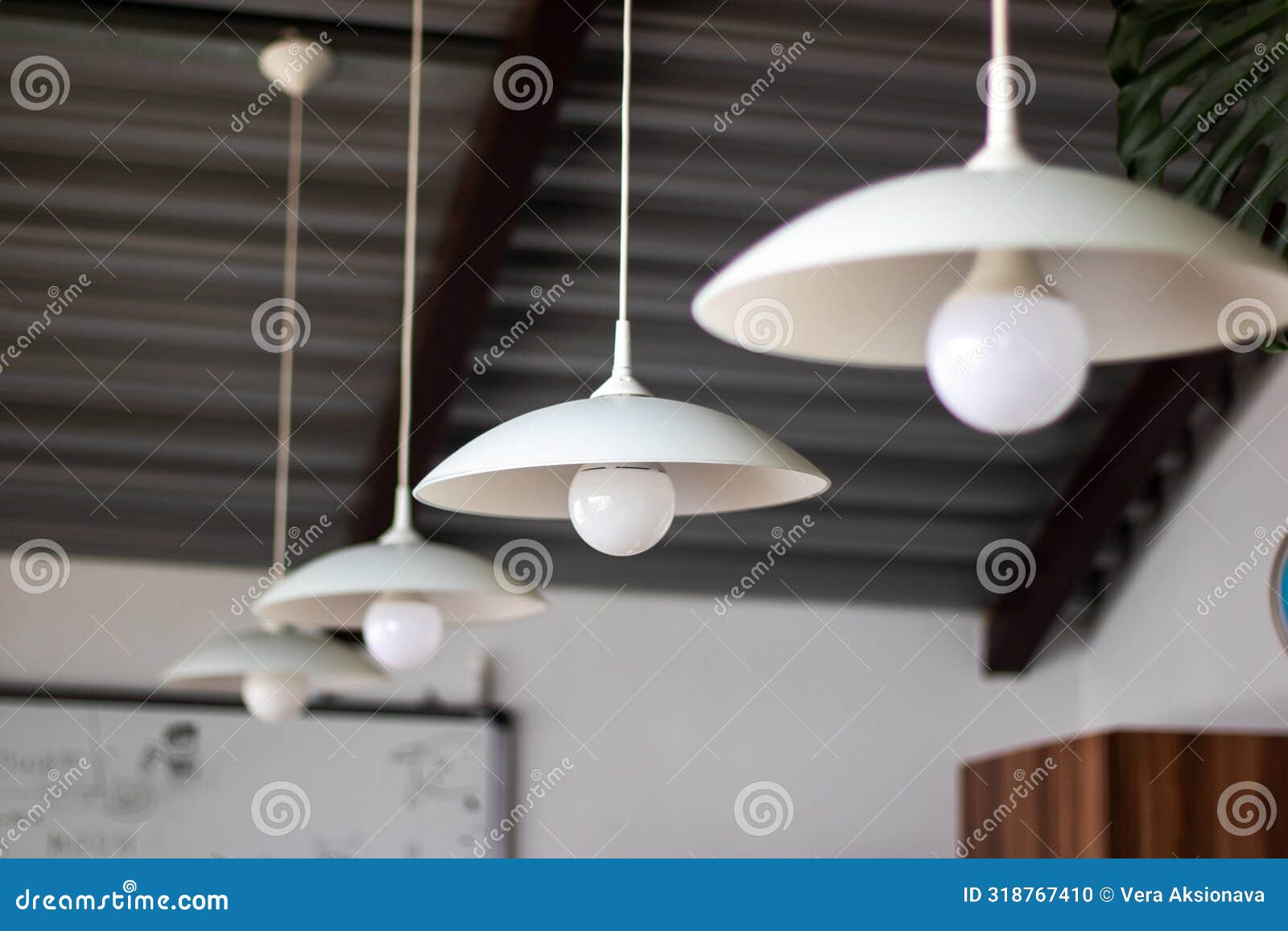 Three Elegant White Pendant Lights are Suspended from the Ceiling Stock ...