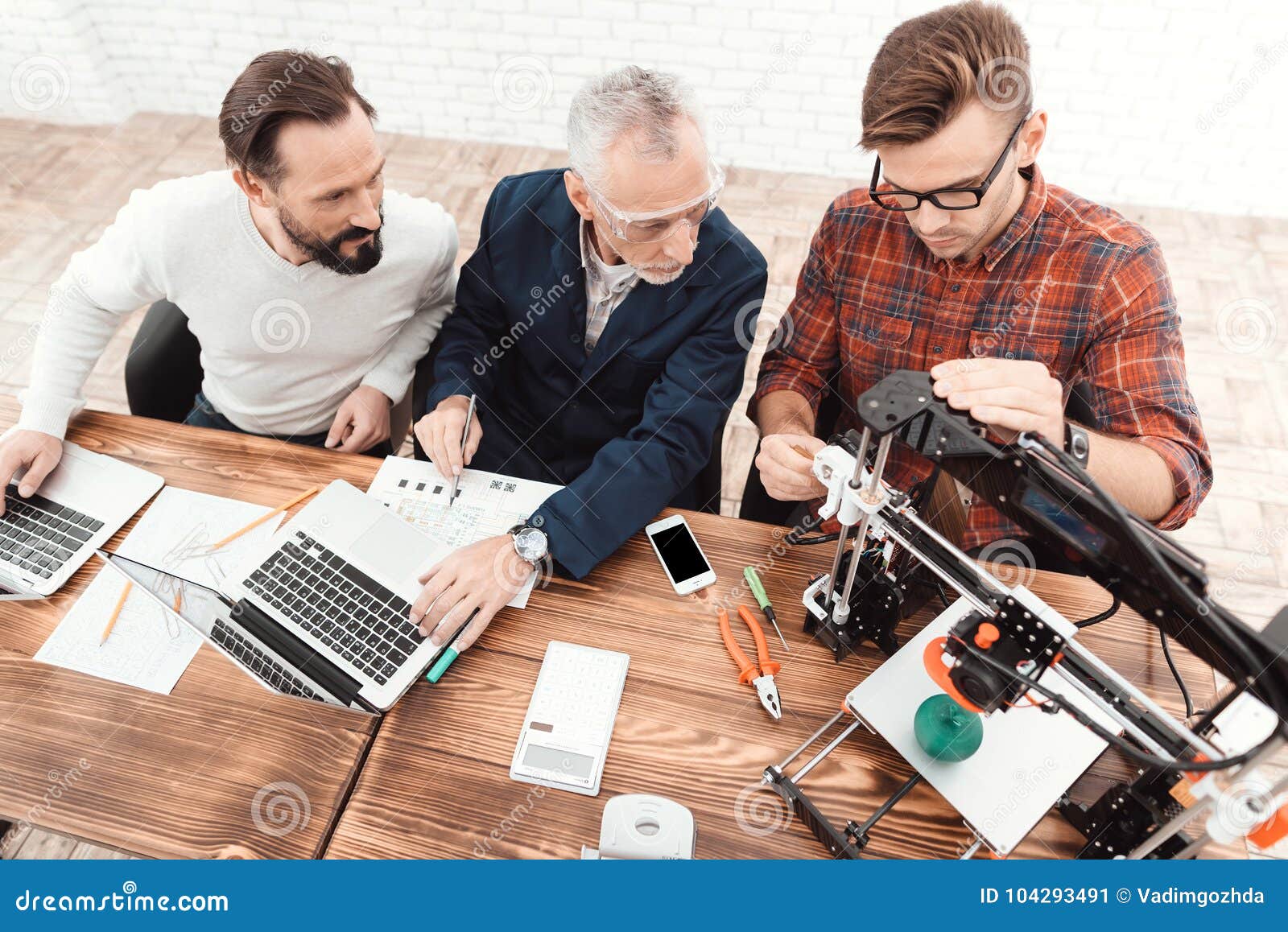 Three Engineers Sit at the Table. Two Work for Computers, while the ...