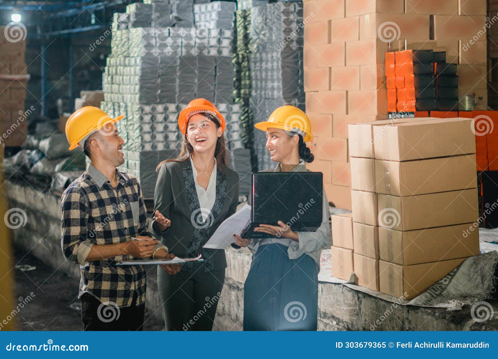 Three Factory Employees Chat while Working Together at the Factory ...