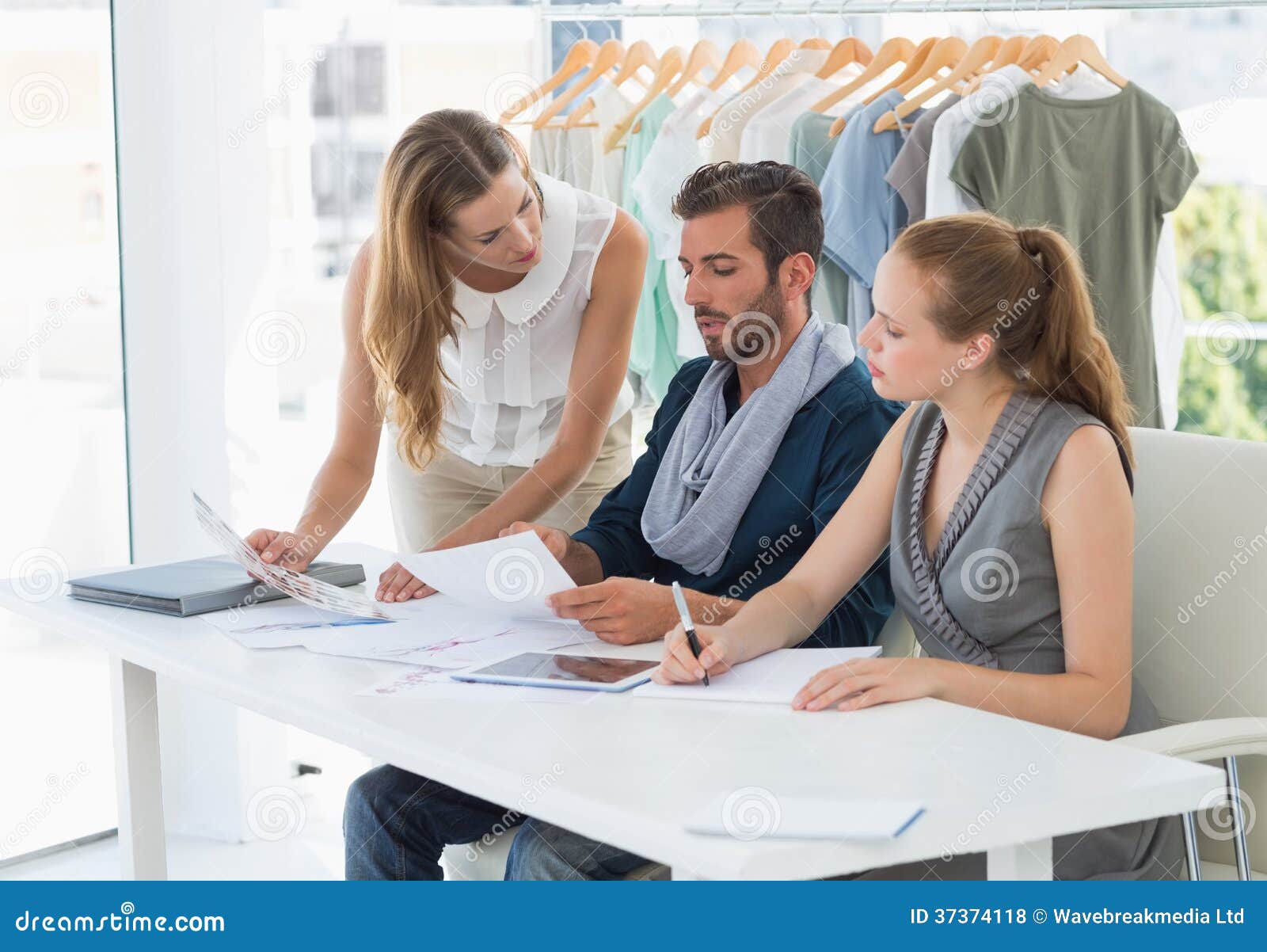 Three Fashion Designers Discussing Designs Stock Photo - Image of ...