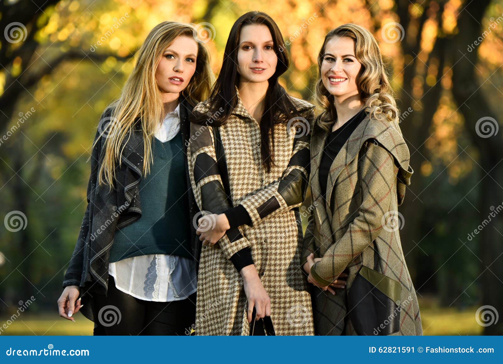 Three Fashion Models Posing Against the Backdrop of the Autumn Park ...