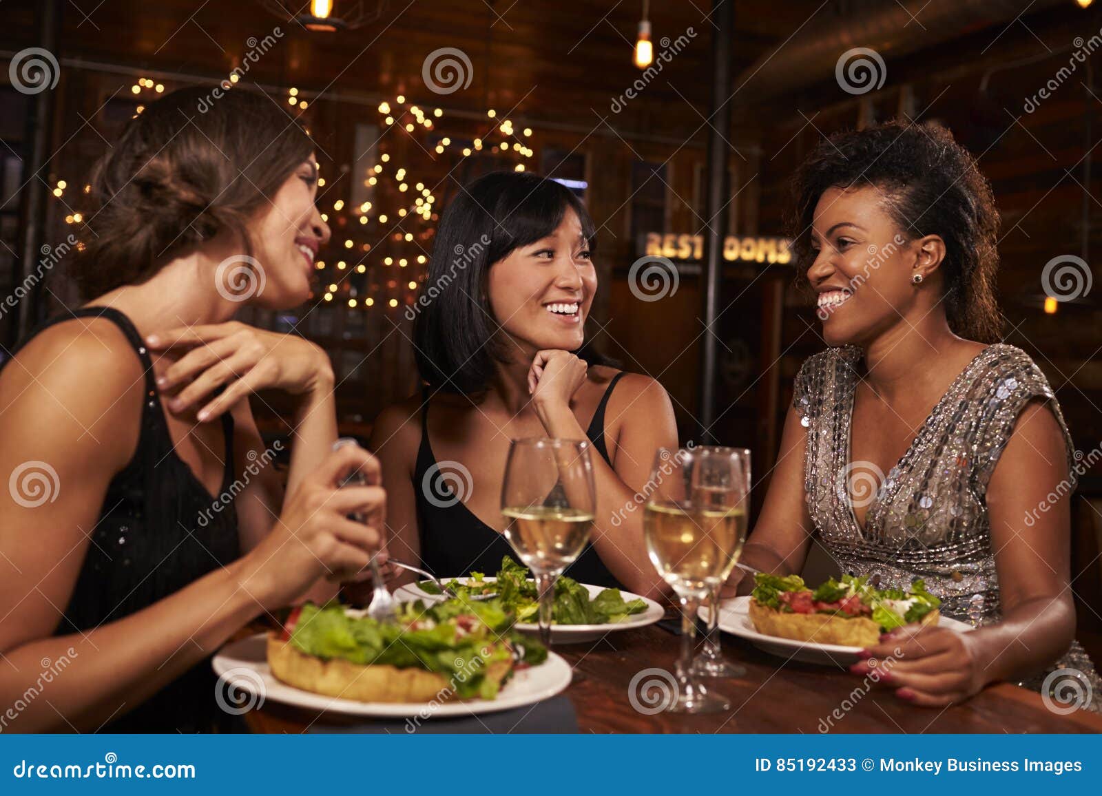 Three Female Friends Eating Dinner Together at a Restaurant Stock Image ...
