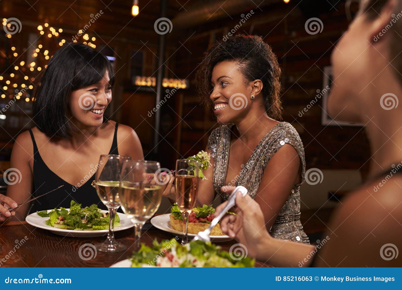 Three Female Friends Enjoying Dinner at a Restaurant Stock Image ...