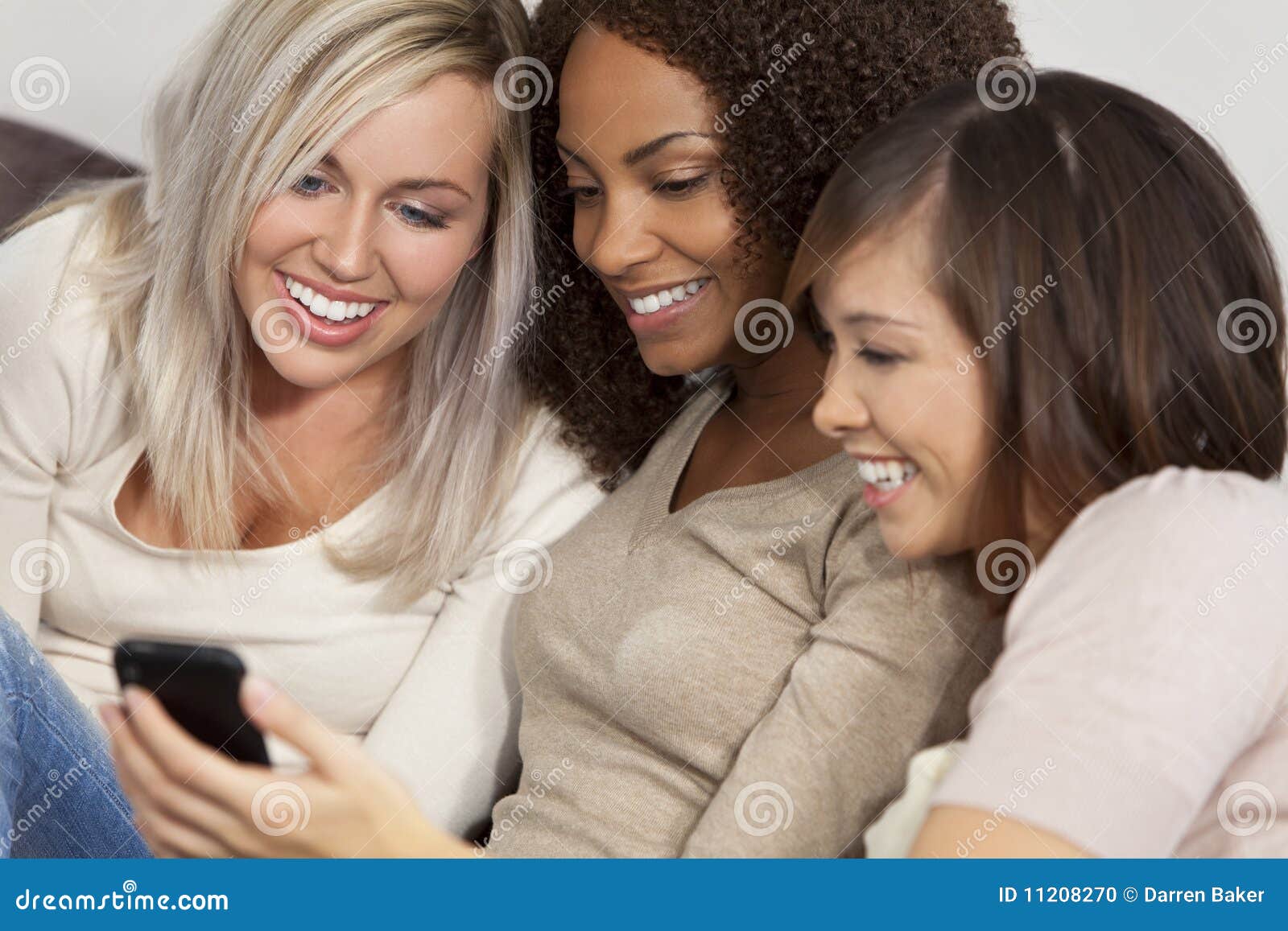 Three Female Friends Laughing with Cell Phone Stock Photo - Image of ...