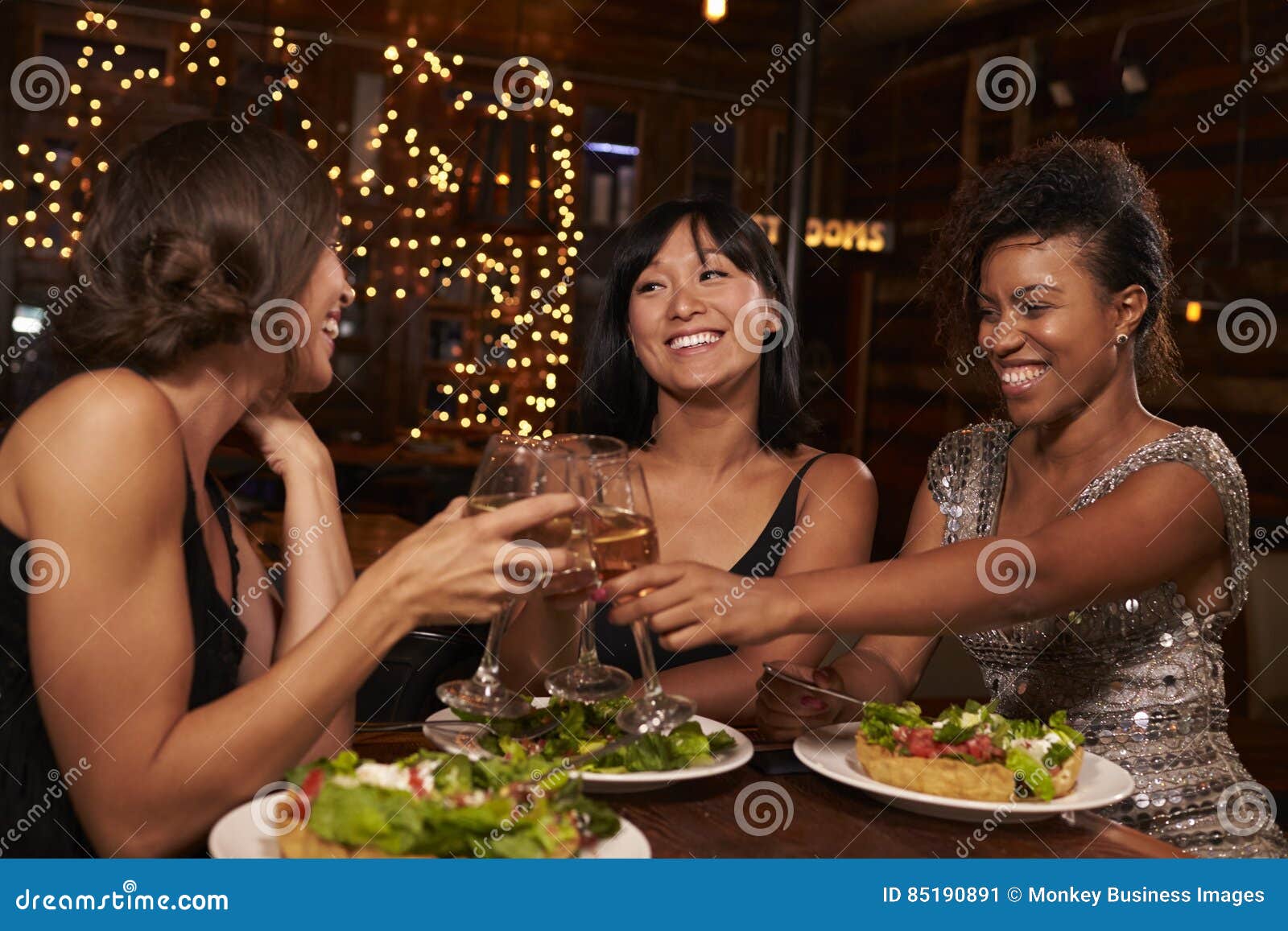 Three Female Friends Make a Toast Over Dinner at Restaurant Stock Image ...