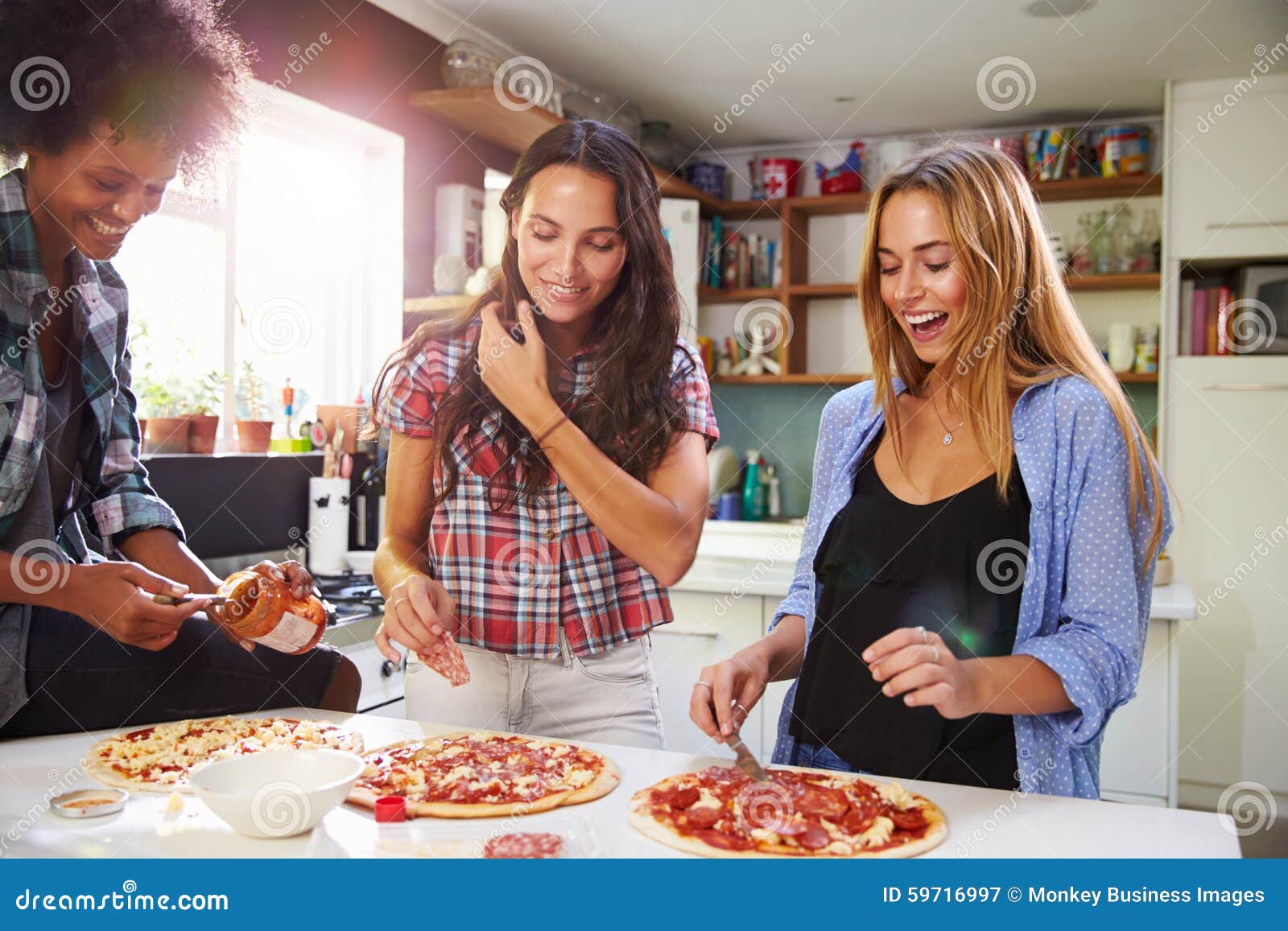 Three Female Friends Making Pizza in Kitchen Together Stock Image ...