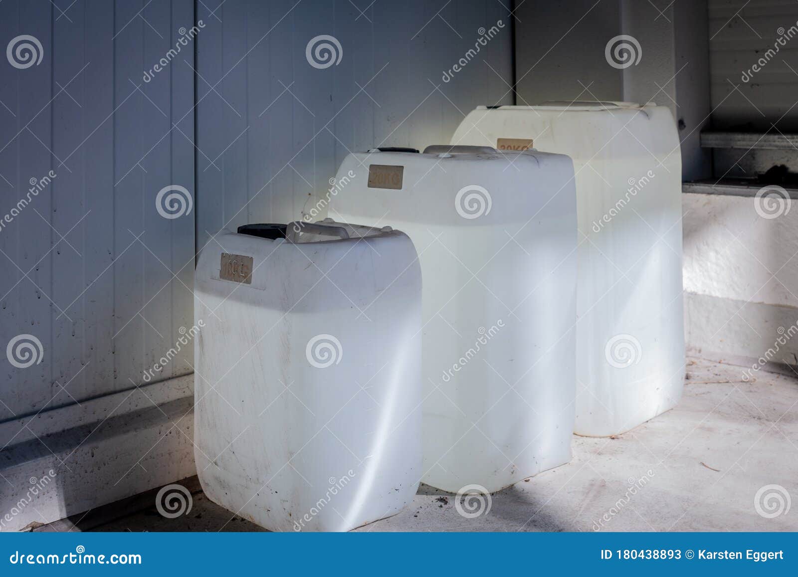 3 Filled White Canisters of Different Sizes Standing on a Wall in a ...