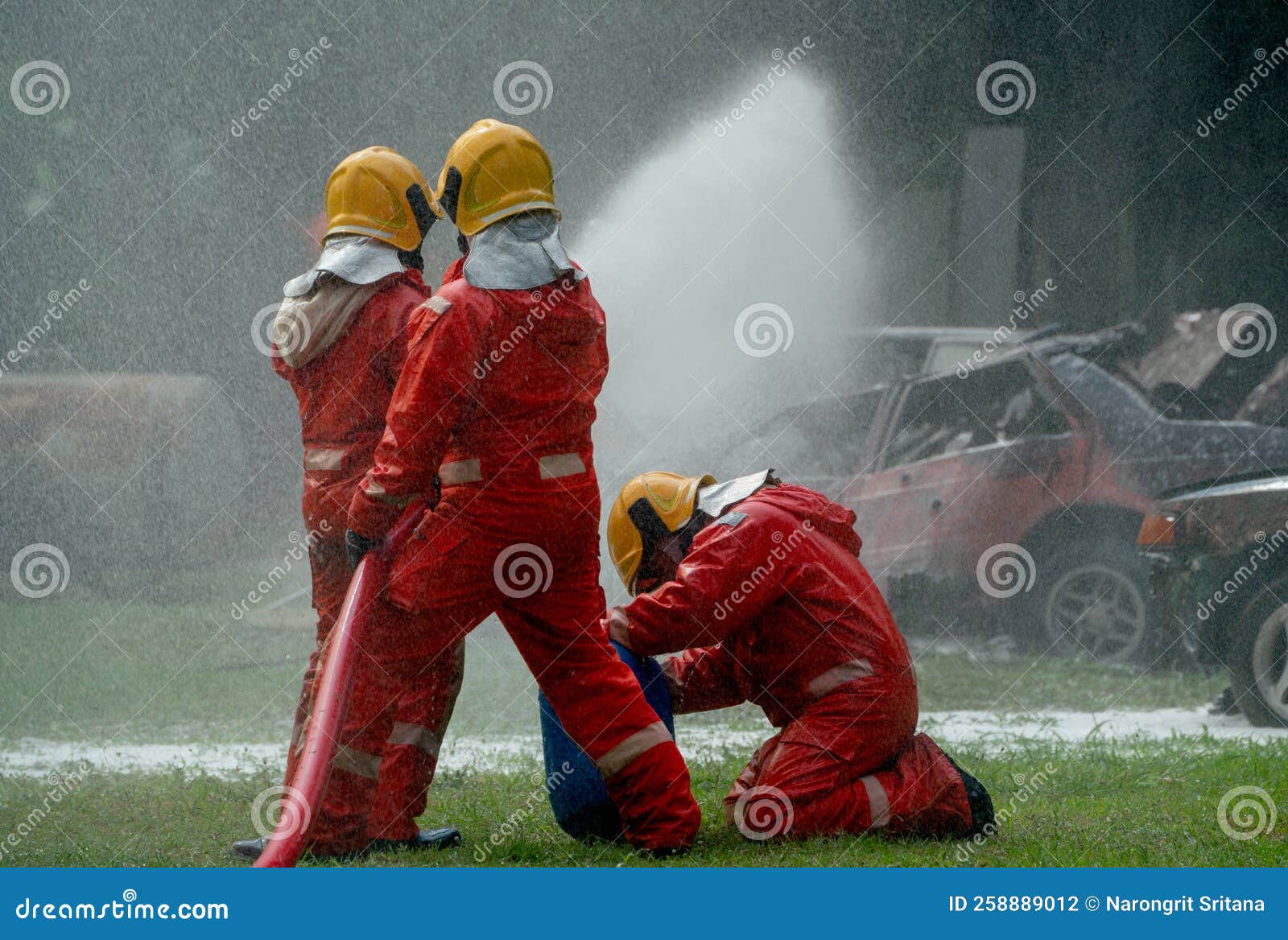 Three Firefighters Help and Support To Use Fire Sprinkler To Spray ...
