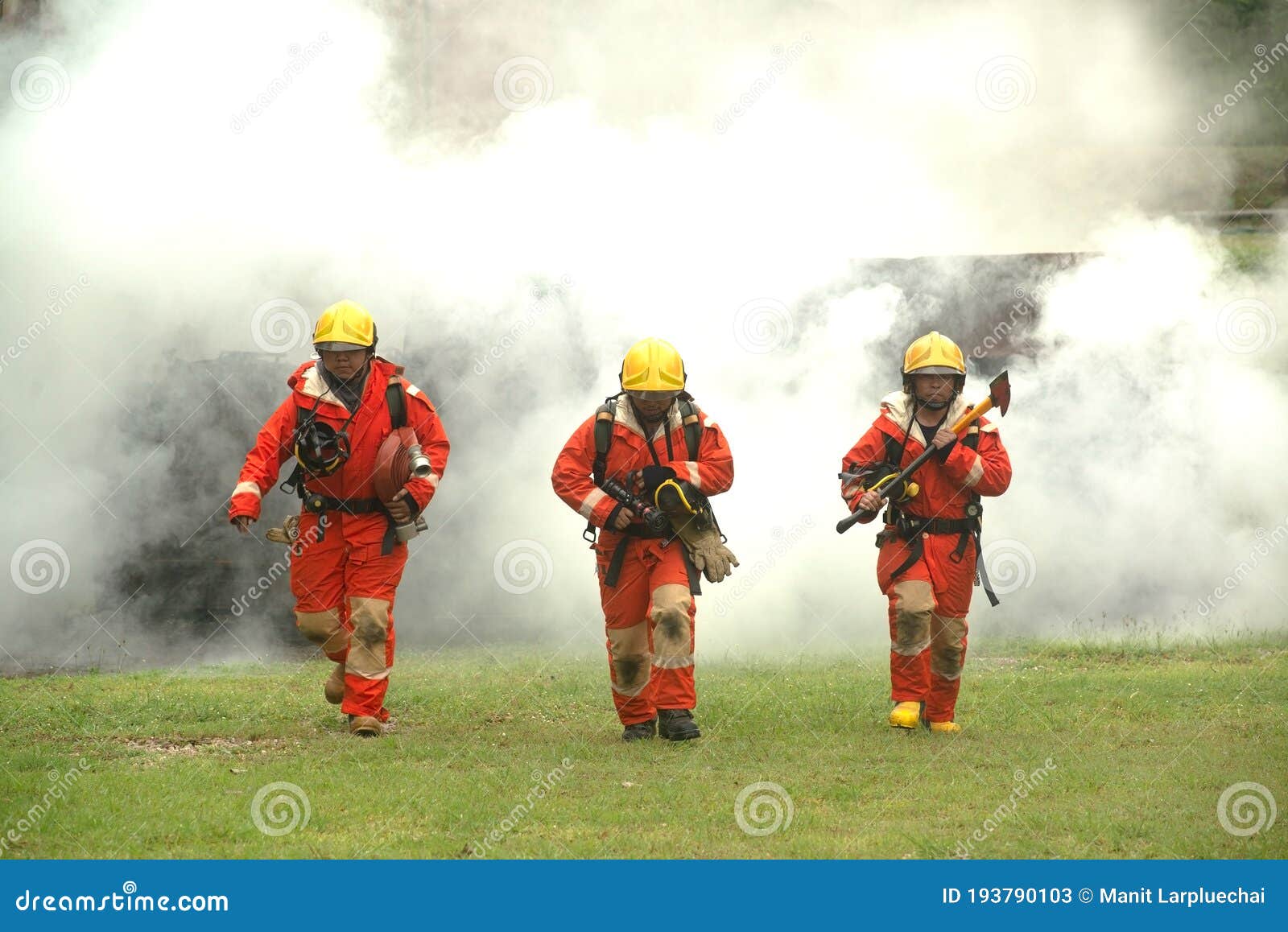 Three Firefighters Were Walking Out of the Smoke from the Fire ...