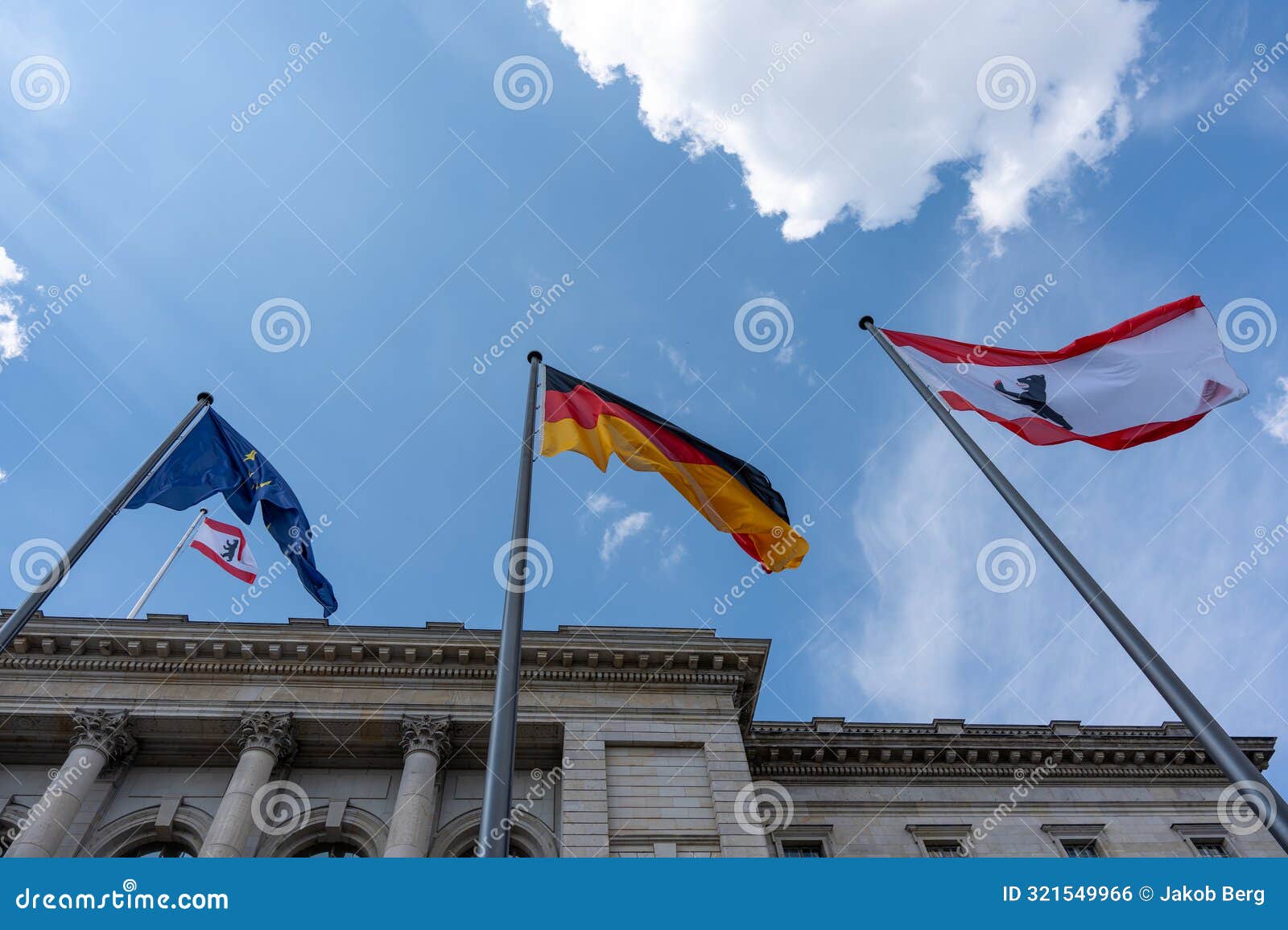 Three Flags are Flying High in the Sky, One of Which is a Red Stock ...