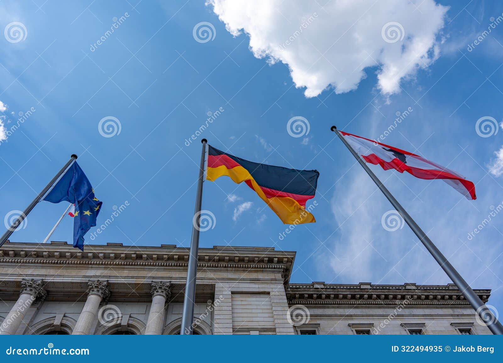 Three Flags are Flying on Poles Outside a Building Stock Image - Image ...