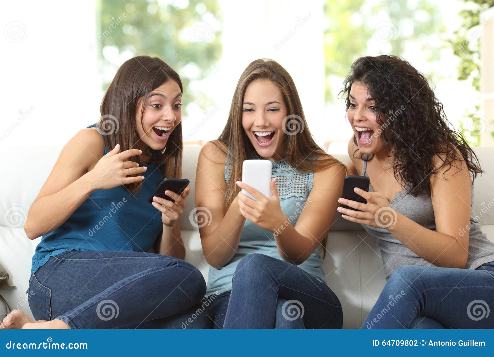 Three Friends Amazed Watching a Smart Phone Stock Photo - Image of ...