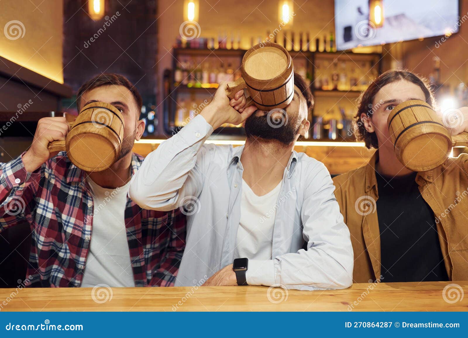 Three Friends are in the Bar Drinking Beer and Having a Good Time Stock ...