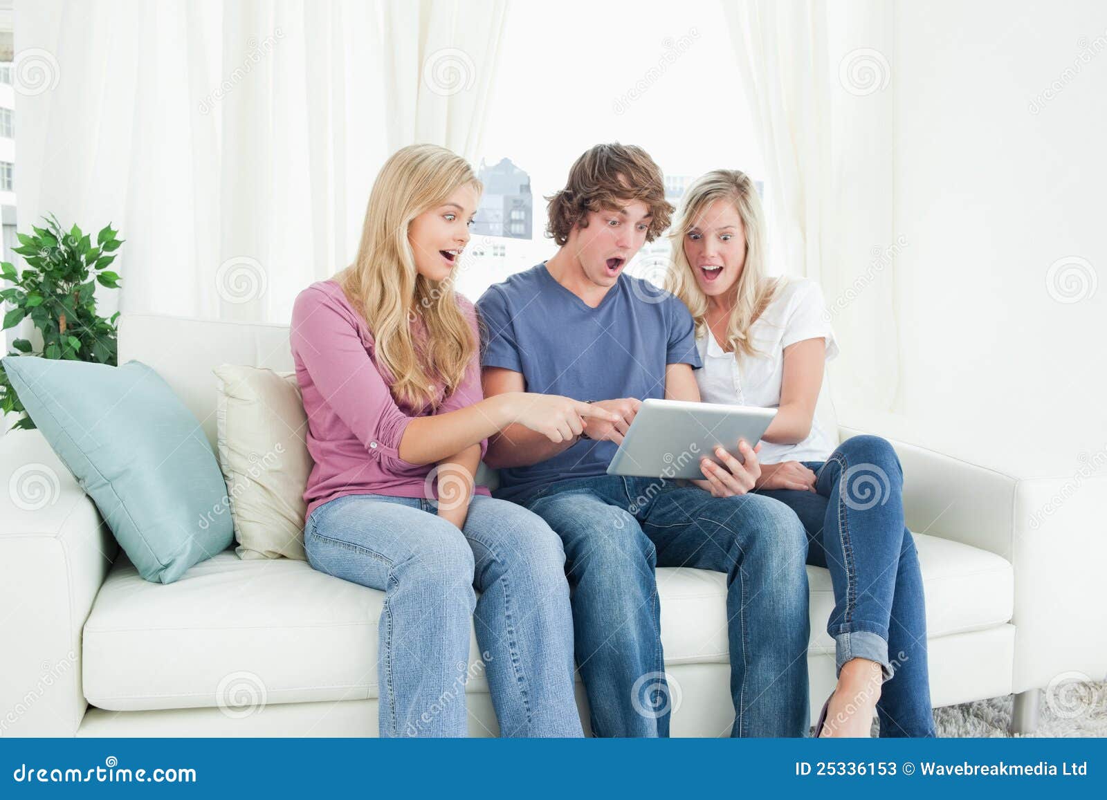 Three Friends Looking at the Screen of the Tablet in Shock Stock Image ...