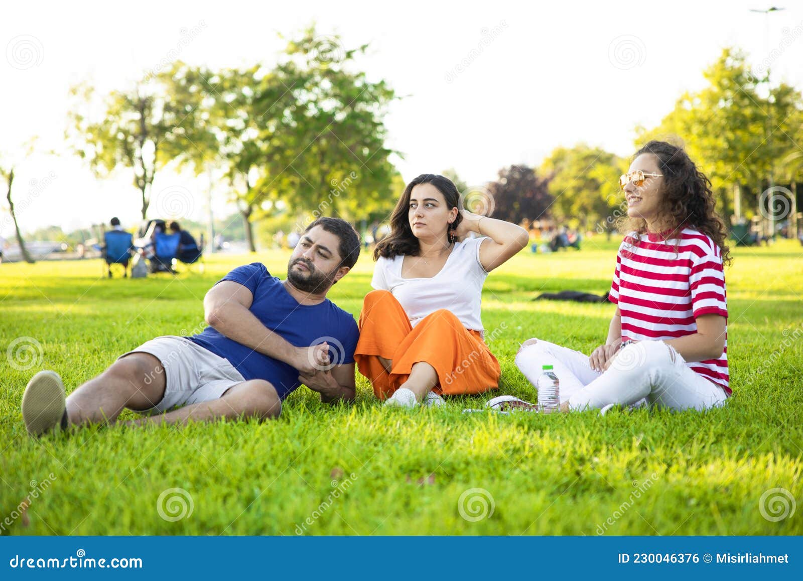 Three Friends Sitting on the Grass in the Park Stock Photo - Image of ...