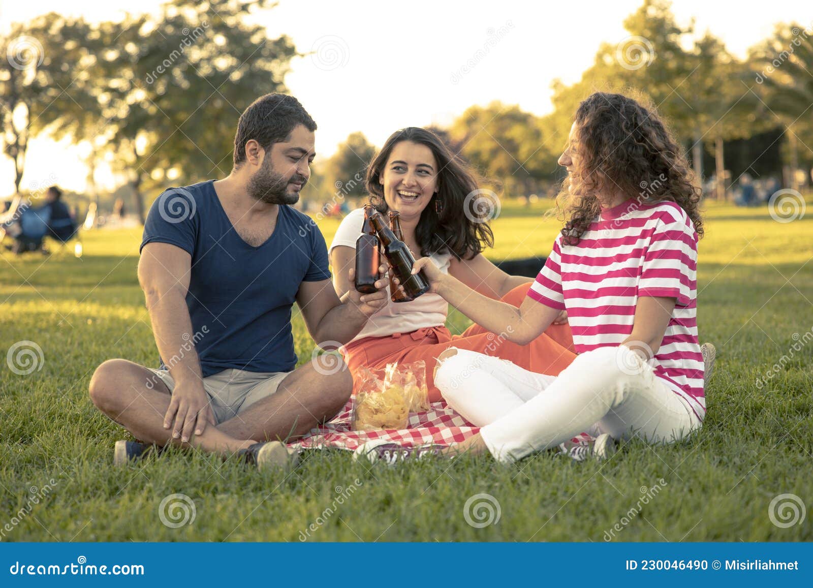 Three Friends Sitting on the Grass in the Park Stock Photo - Image of ...