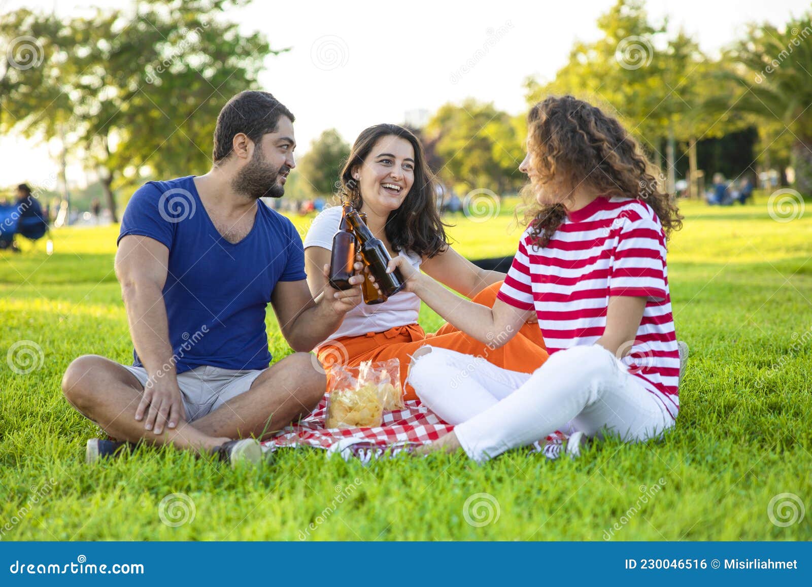 Three Friends Sitting on the Grass in the Park Stock Photo - Image of ...