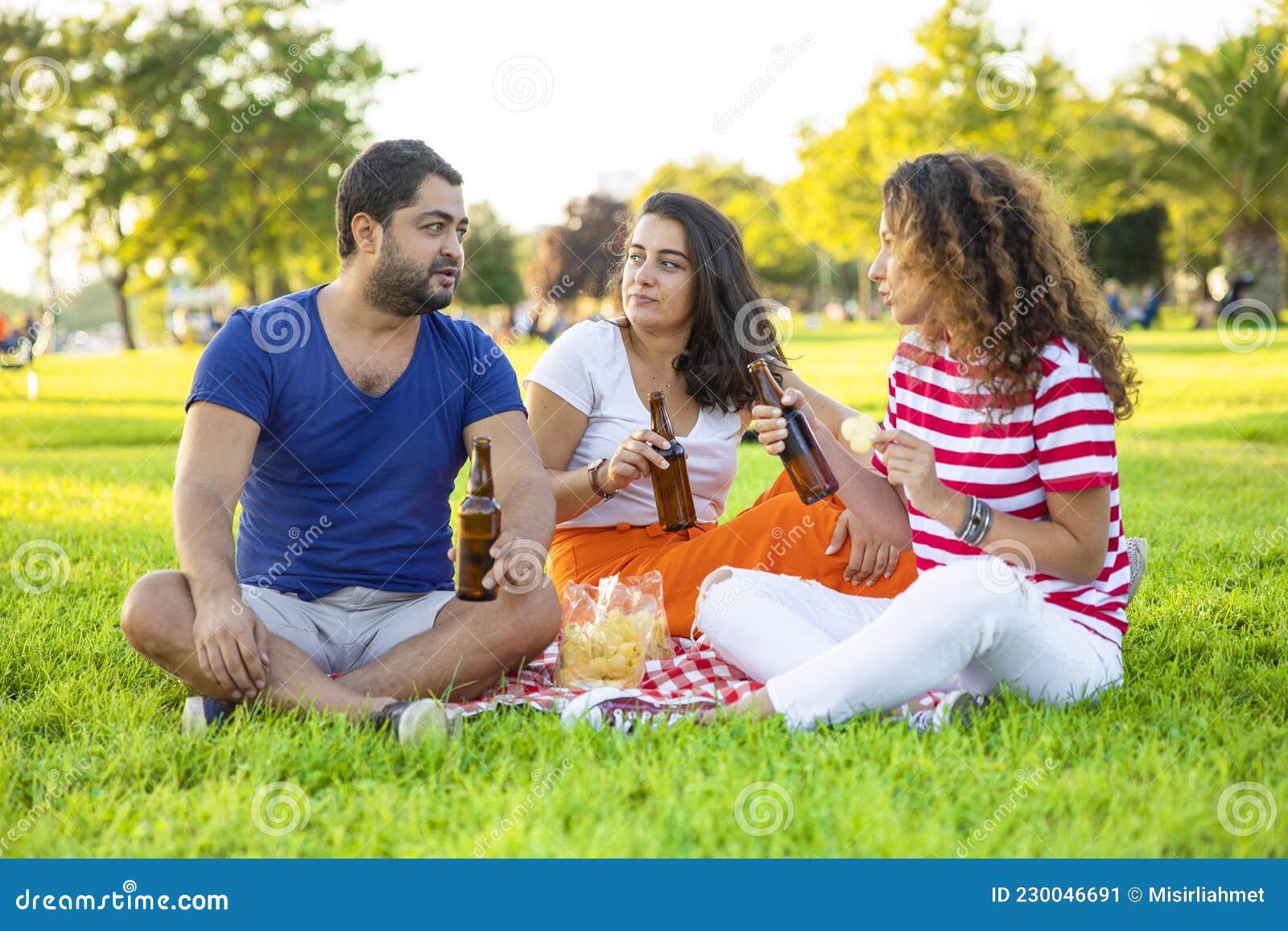 Three Friends Sitting on the Grass in the Park Stock Image - Image of ...