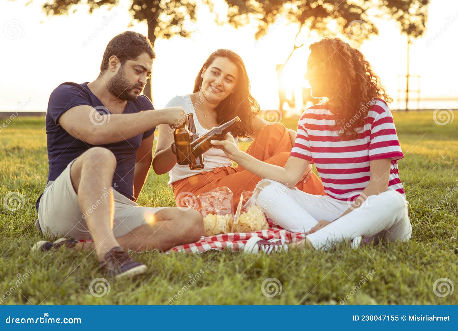 Three Friends Sitting on the Grass in the Park Stock Image - Image of ...
