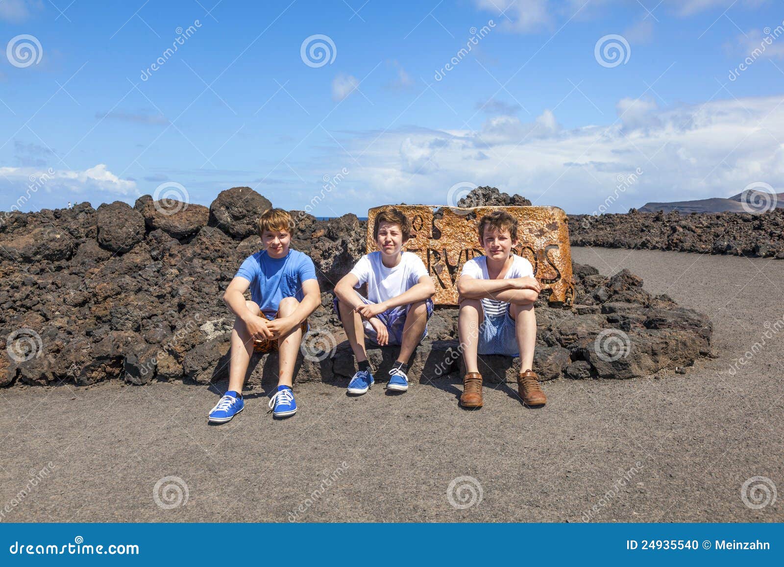 Three Friends Sitting on a Rock and Have a Rest Stock Photo - Image of ...