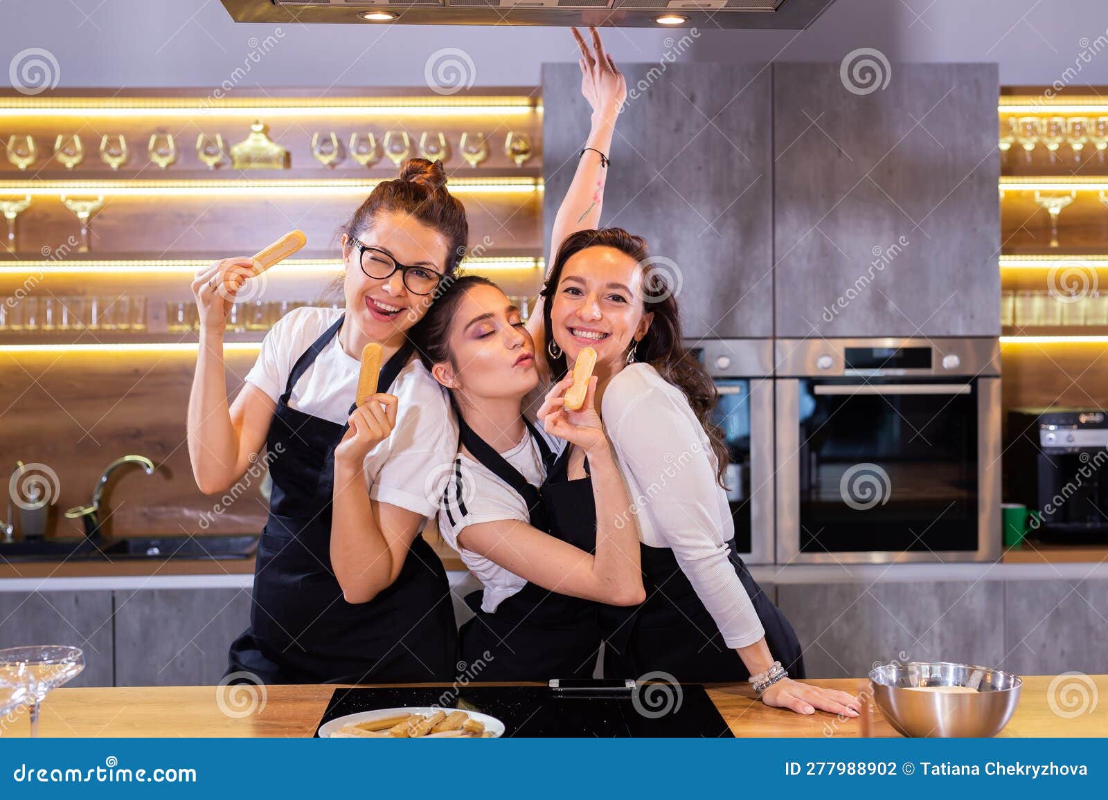 Three Funny Female Chef in Uniform Holding Cookies while Smiling and ...