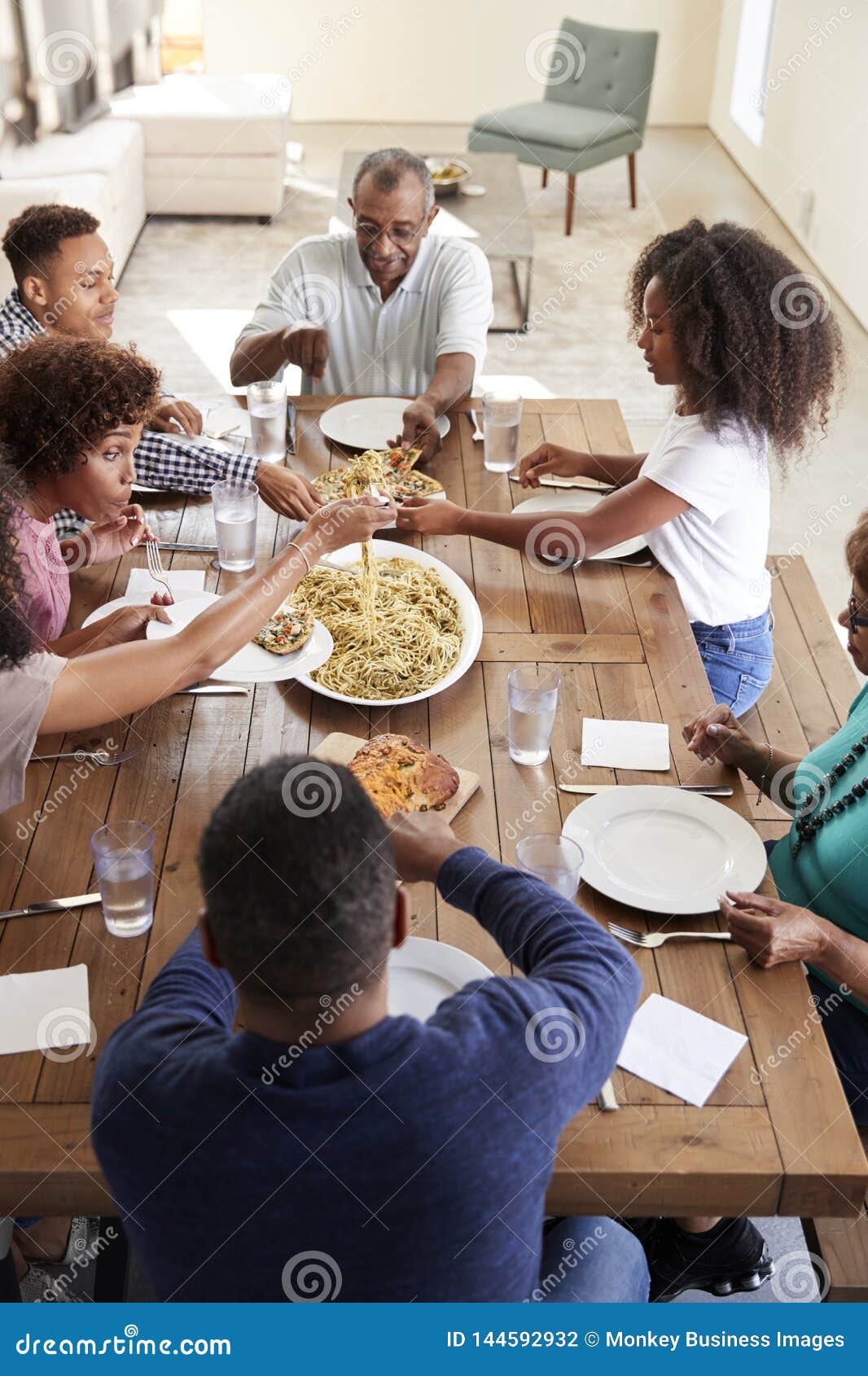 Three Generation African American Family Sitting at Dinner Table Eating ...
