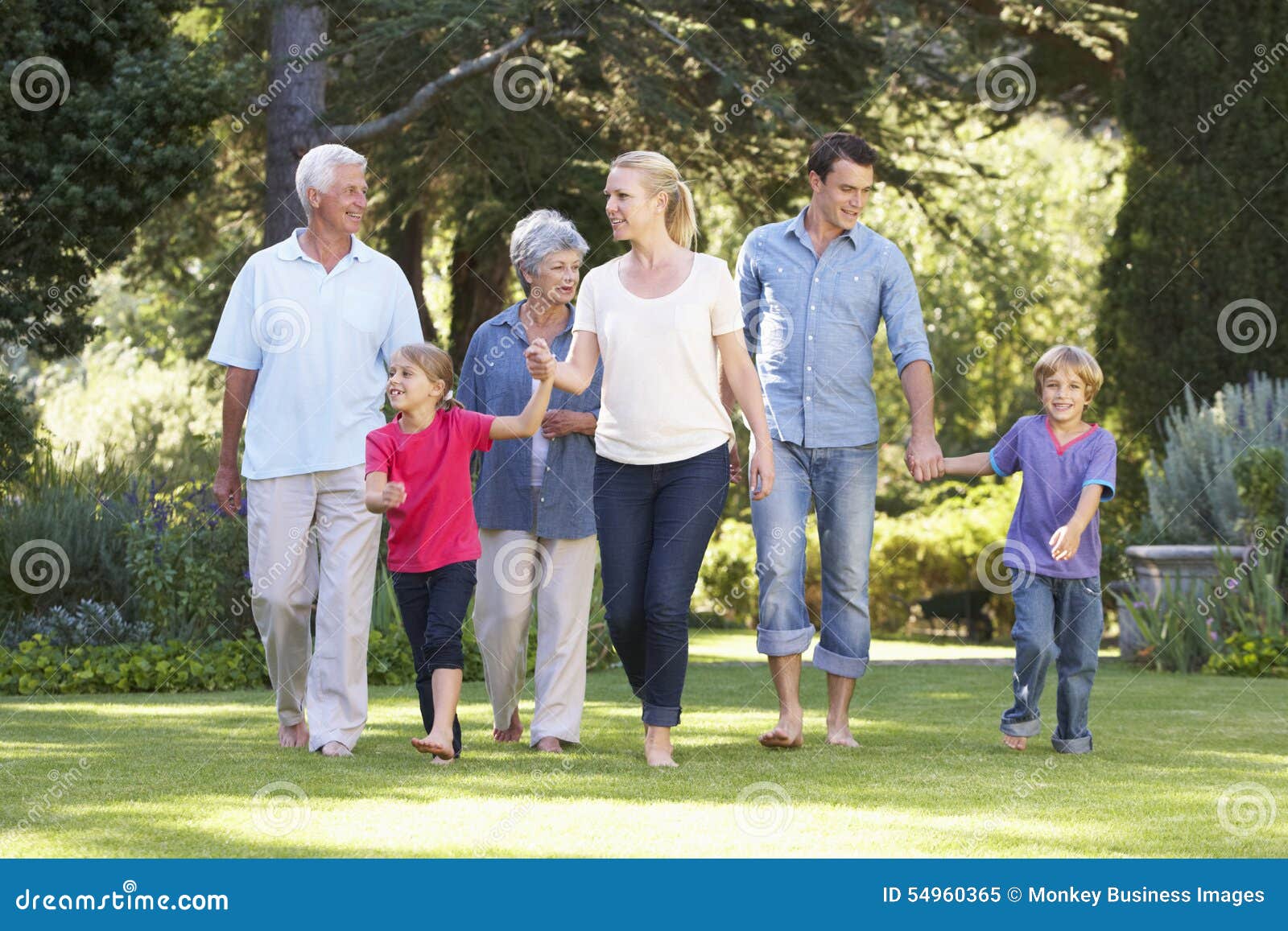 Three Generation Family Walking in Garden Together Stock Image - Image ...