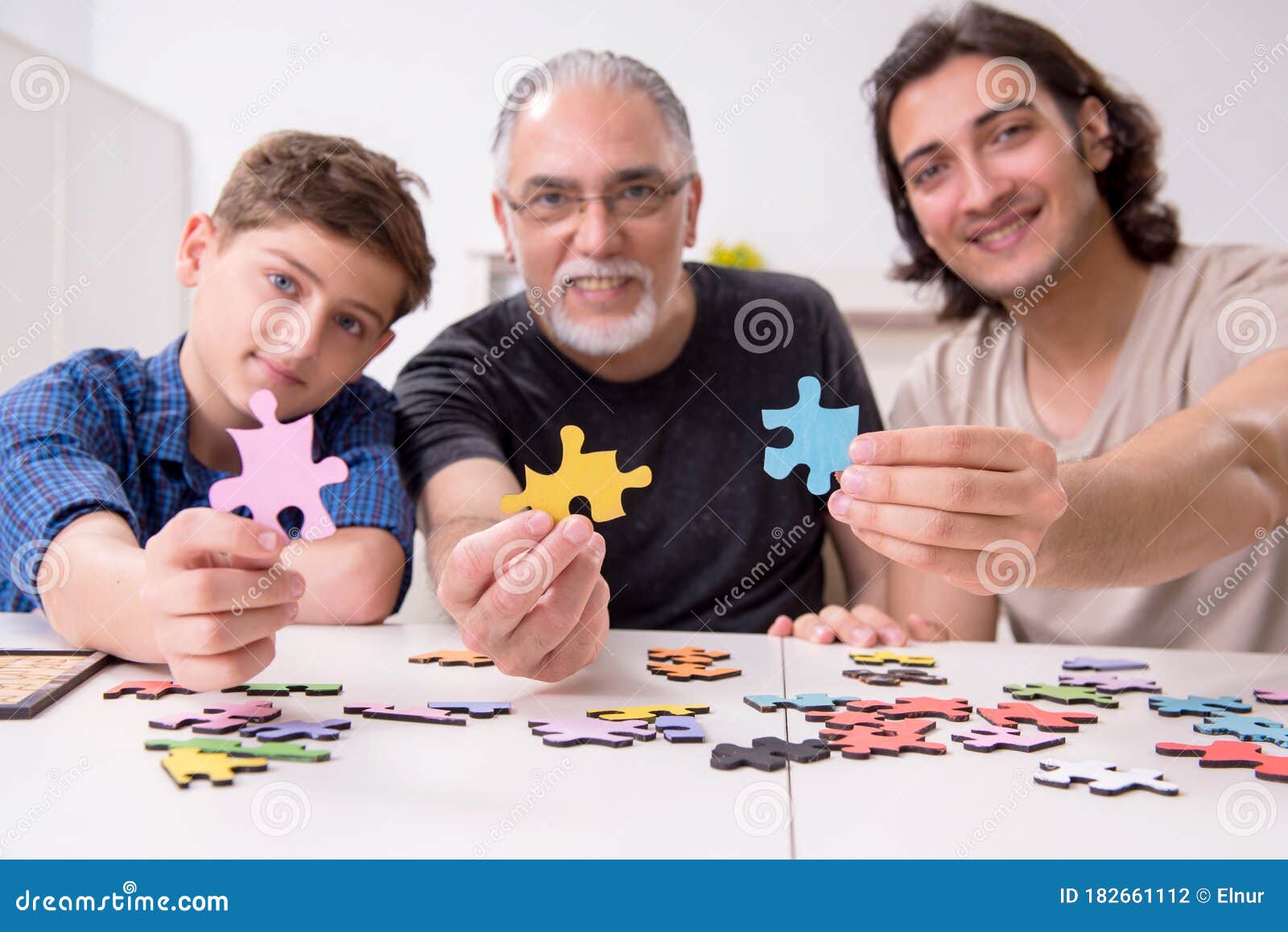 Three Generations of Family Playing Jigsaw Puzzle Game Stock Photo ...
