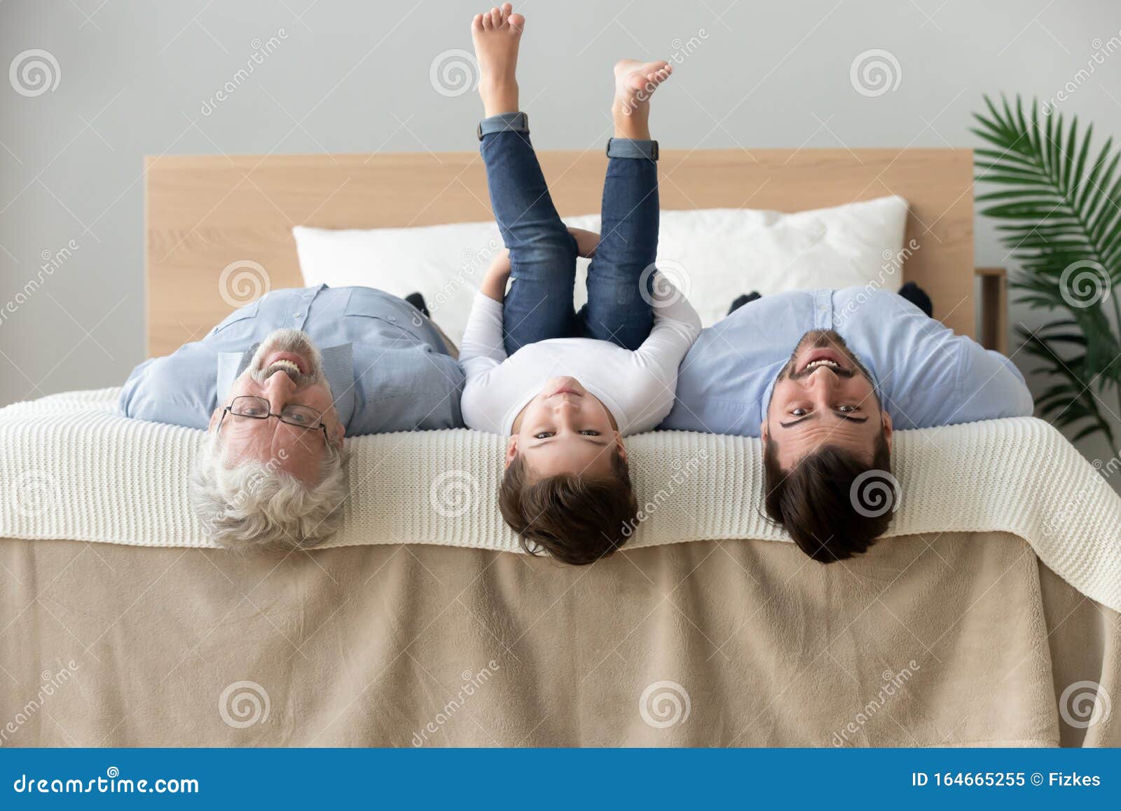 Three Generations of Men Lying on Bed Together, Having Fun Stock Image ...