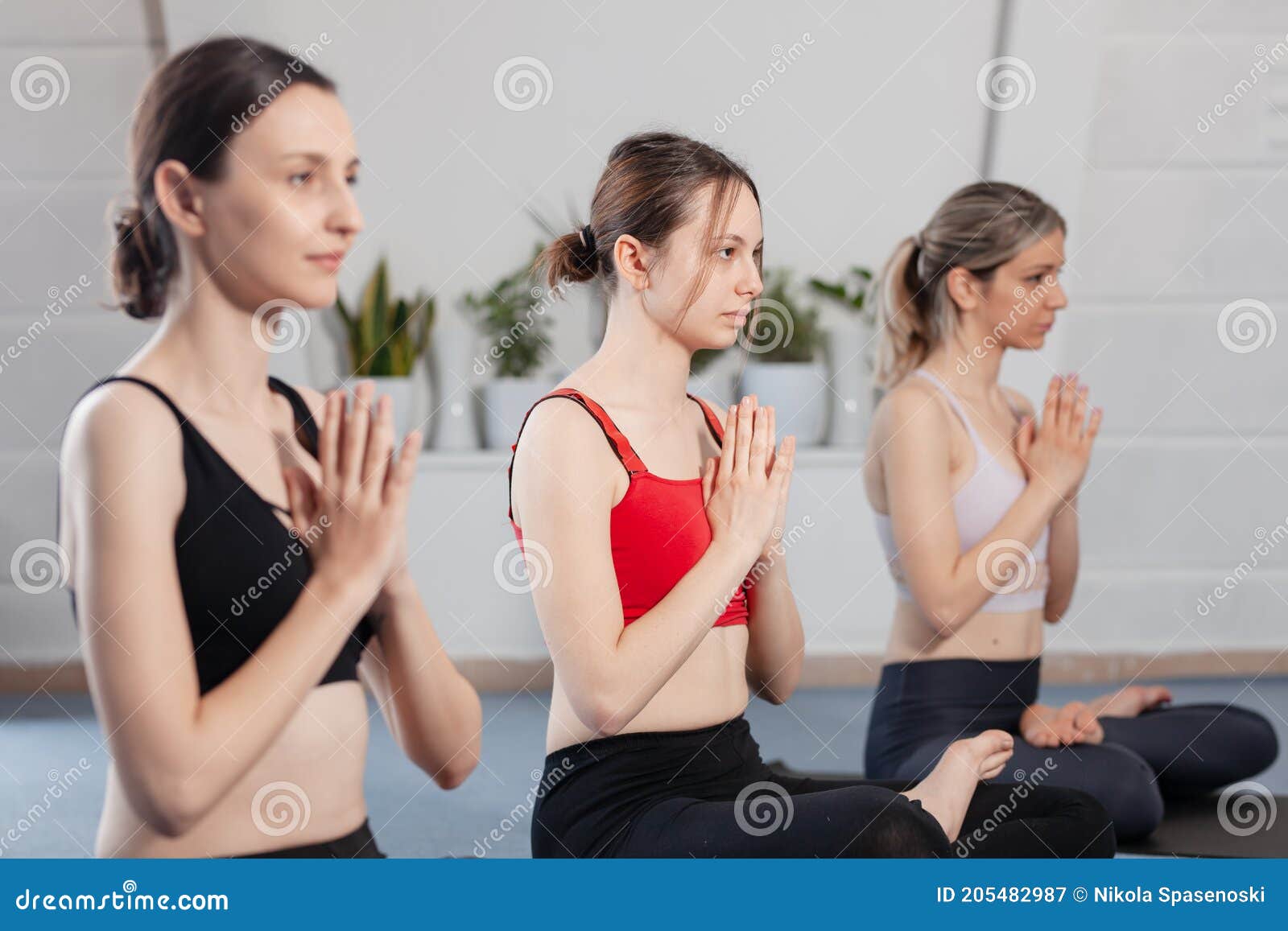 Three Girls Practicing Yoga. Yoga Instructor with Her Students ...