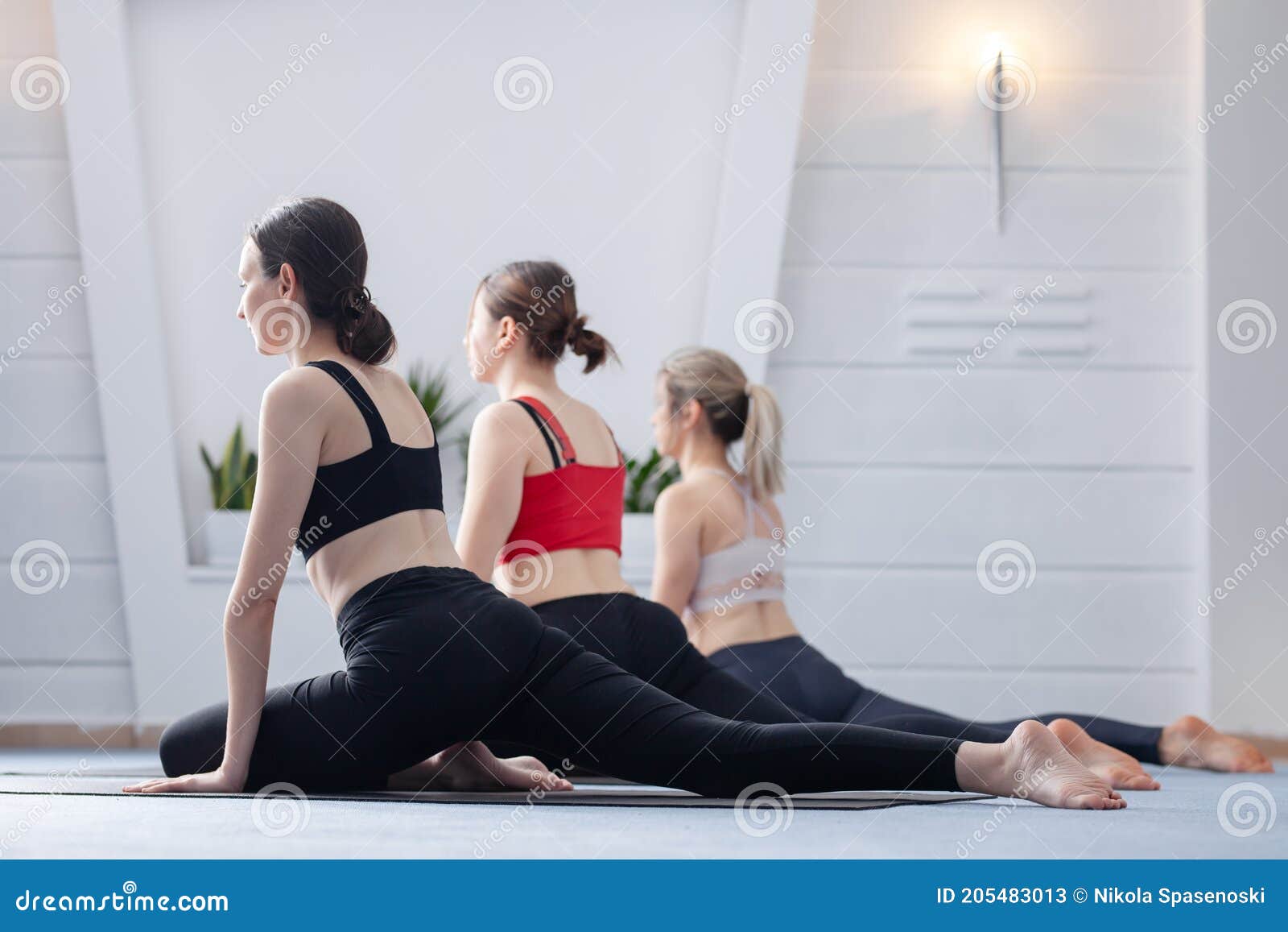 Three Girls Practicing Yoga. Yoga Instructor with Her Students ...