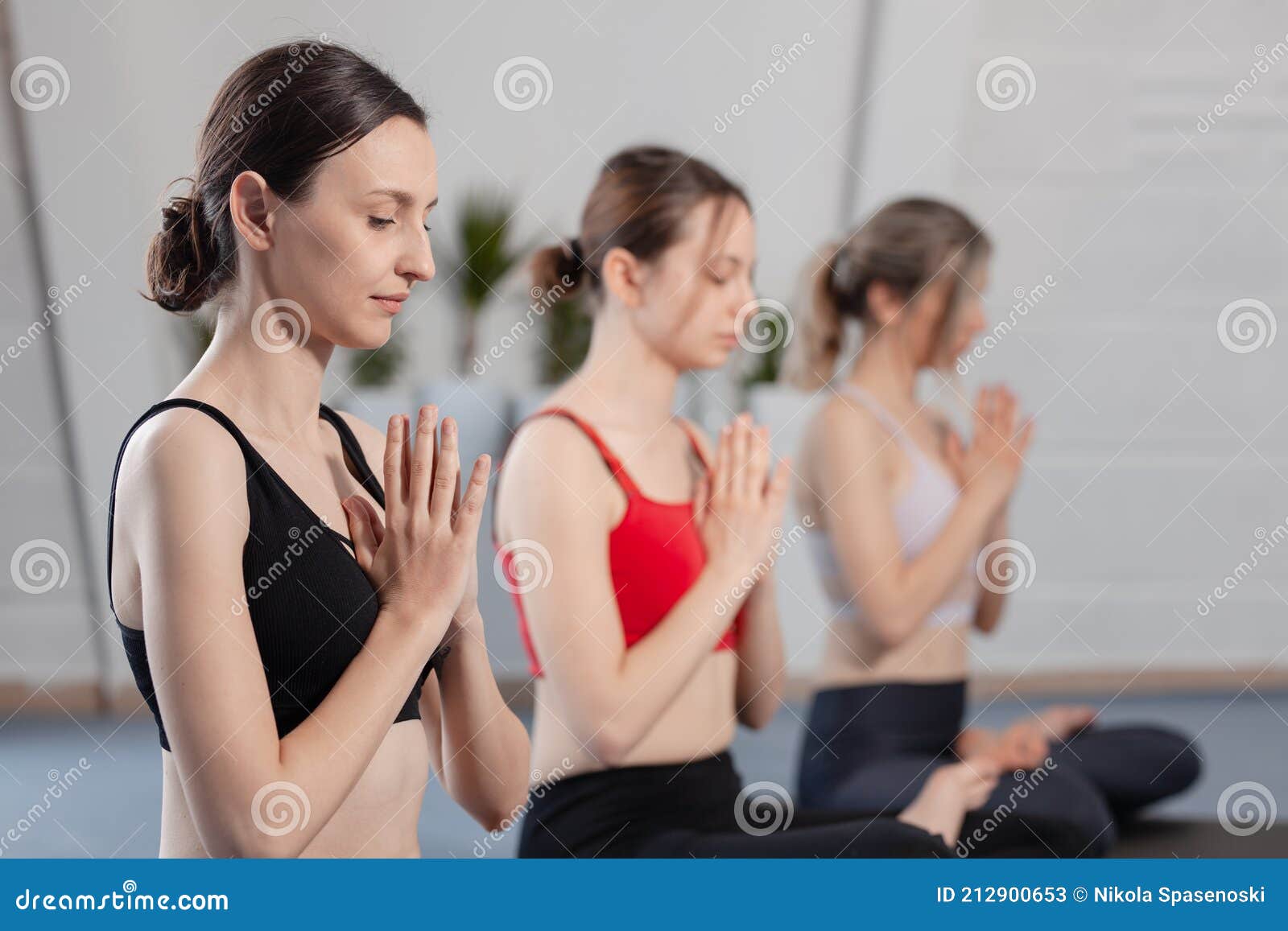 Three Girls Practicing Yoga. Yoga Instructor with Her Students ...
