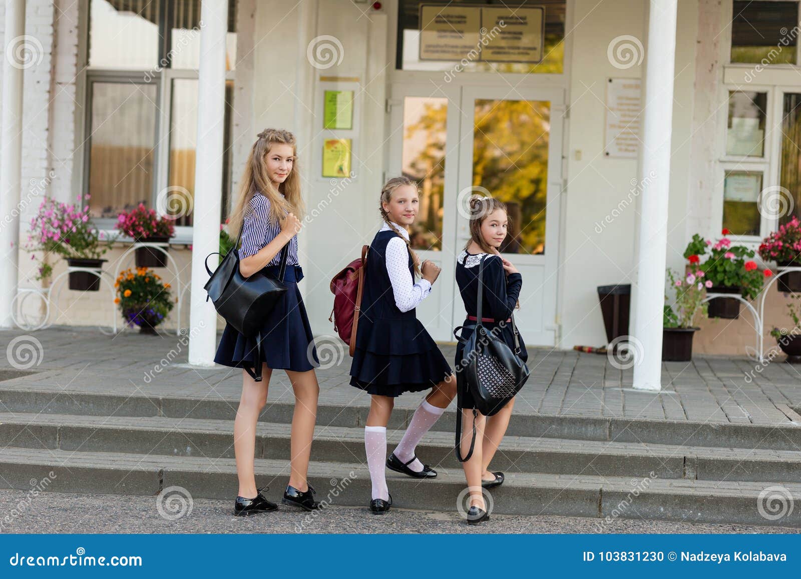 Three Girls in School Uniform with Backpacks Stand on the Steps Stock ...