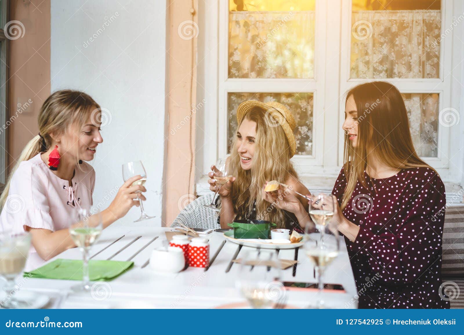 Three girls at the table stock image. Image of attractive - 127542925