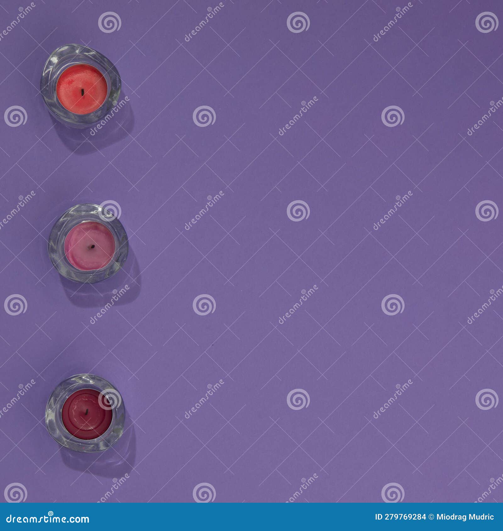 Three Glass Candlesticks with Colored Candles Lined Up Vertically on ...