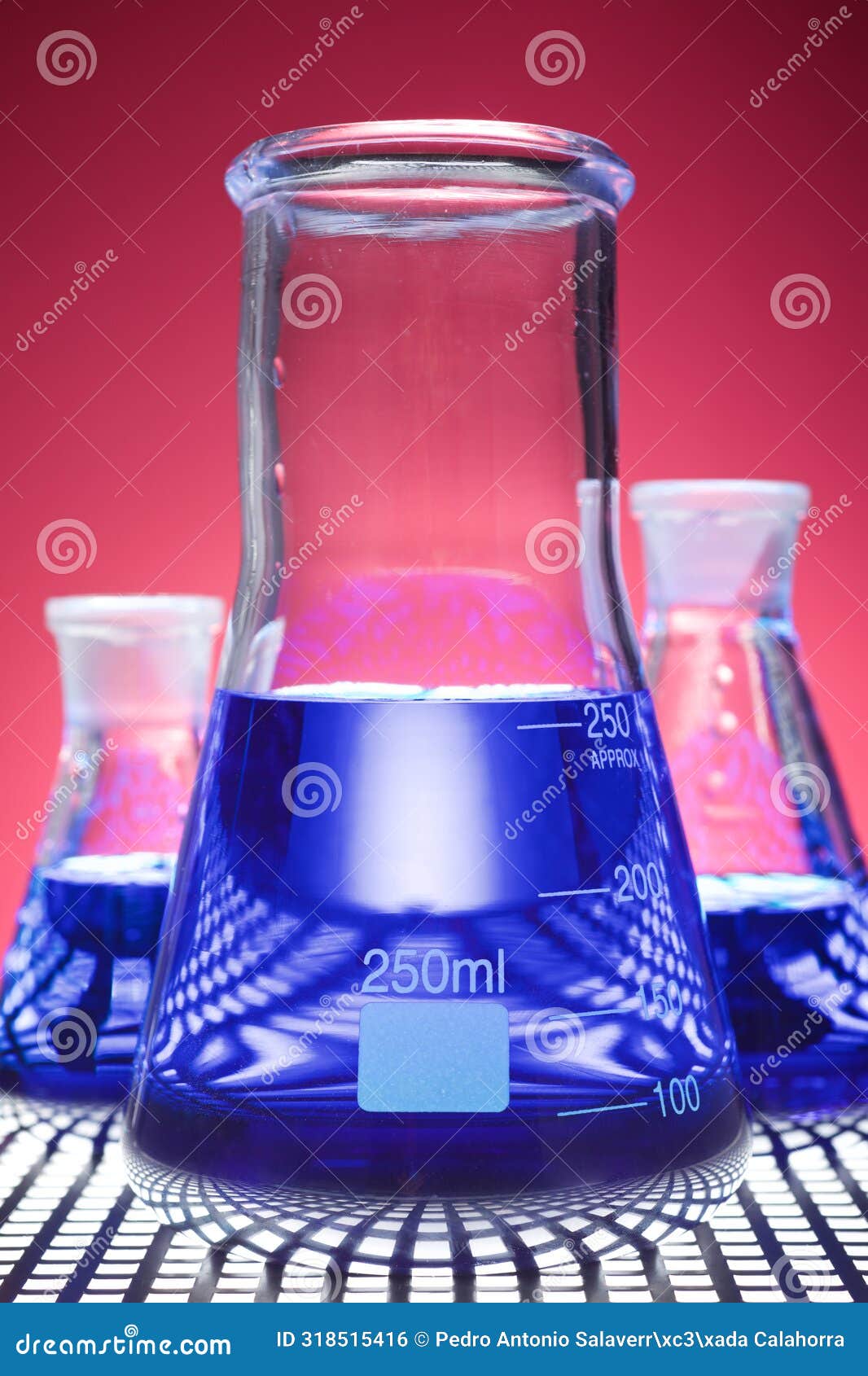 Three Glass Flasks Placed in a Laboratory Table with Blue Liquid Stock ...