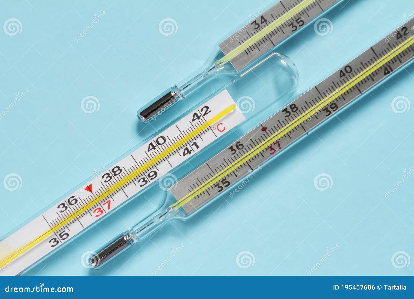 Three Glass Medical Thermometers on a Blue Background Stock Photo ...
