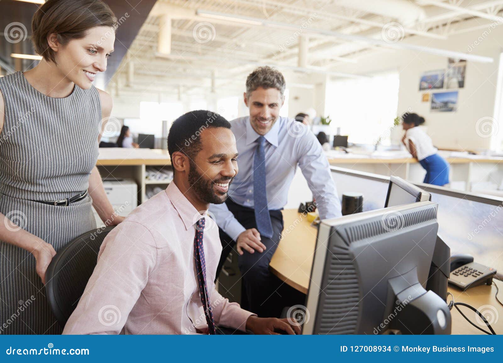 Three Happy Colleagues Looking at a Computer Screen Together Stock ...