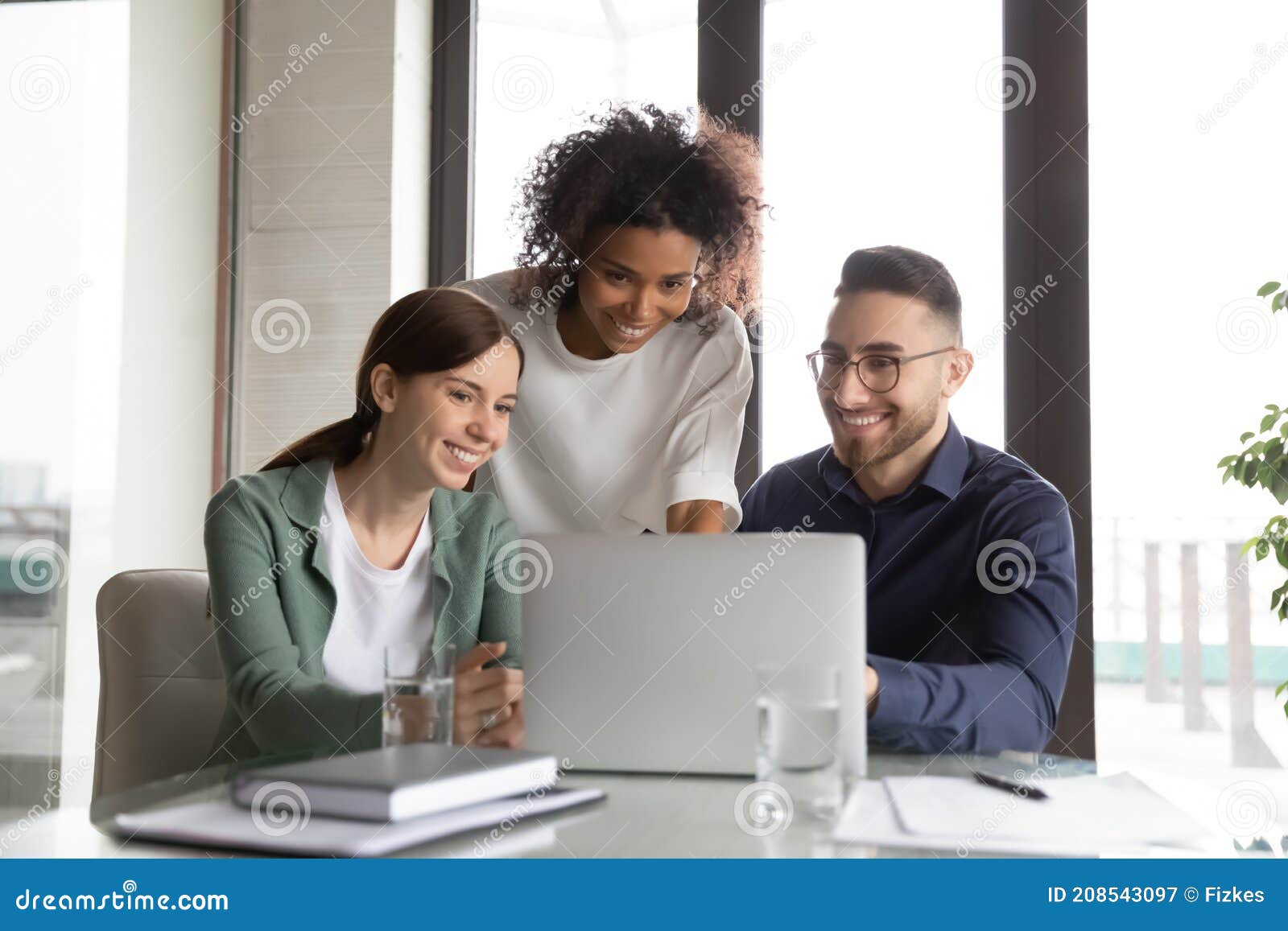 Three Happy Diverse Colleagues Working on Project Together, Using ...