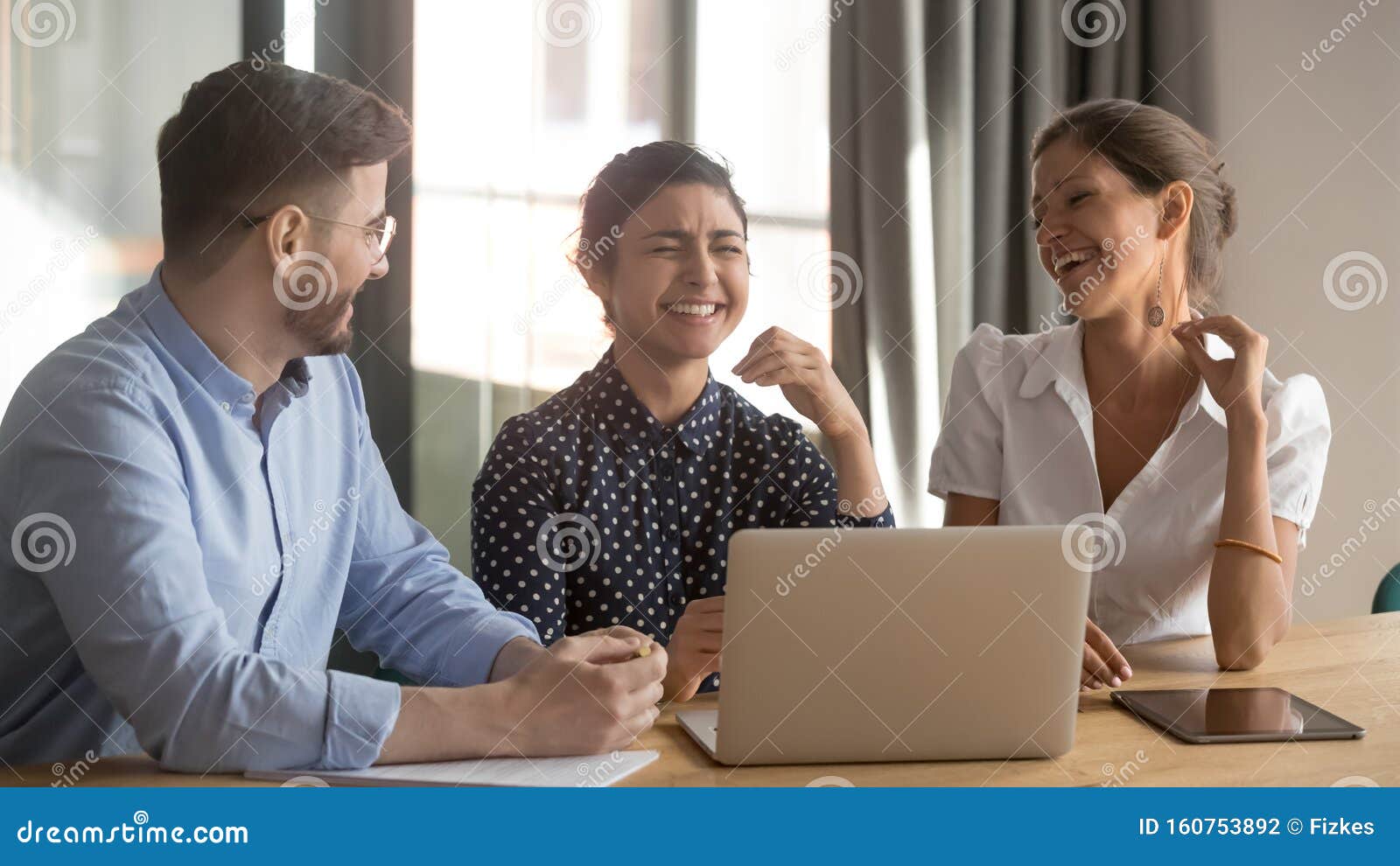 Three Happy Diverse Coworkers Talking Laughing Working Together With