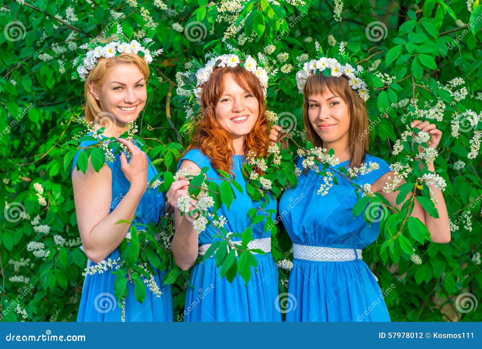 Three Happy Girls in Identical Dresses Posing in the Garden Stock Photo ...