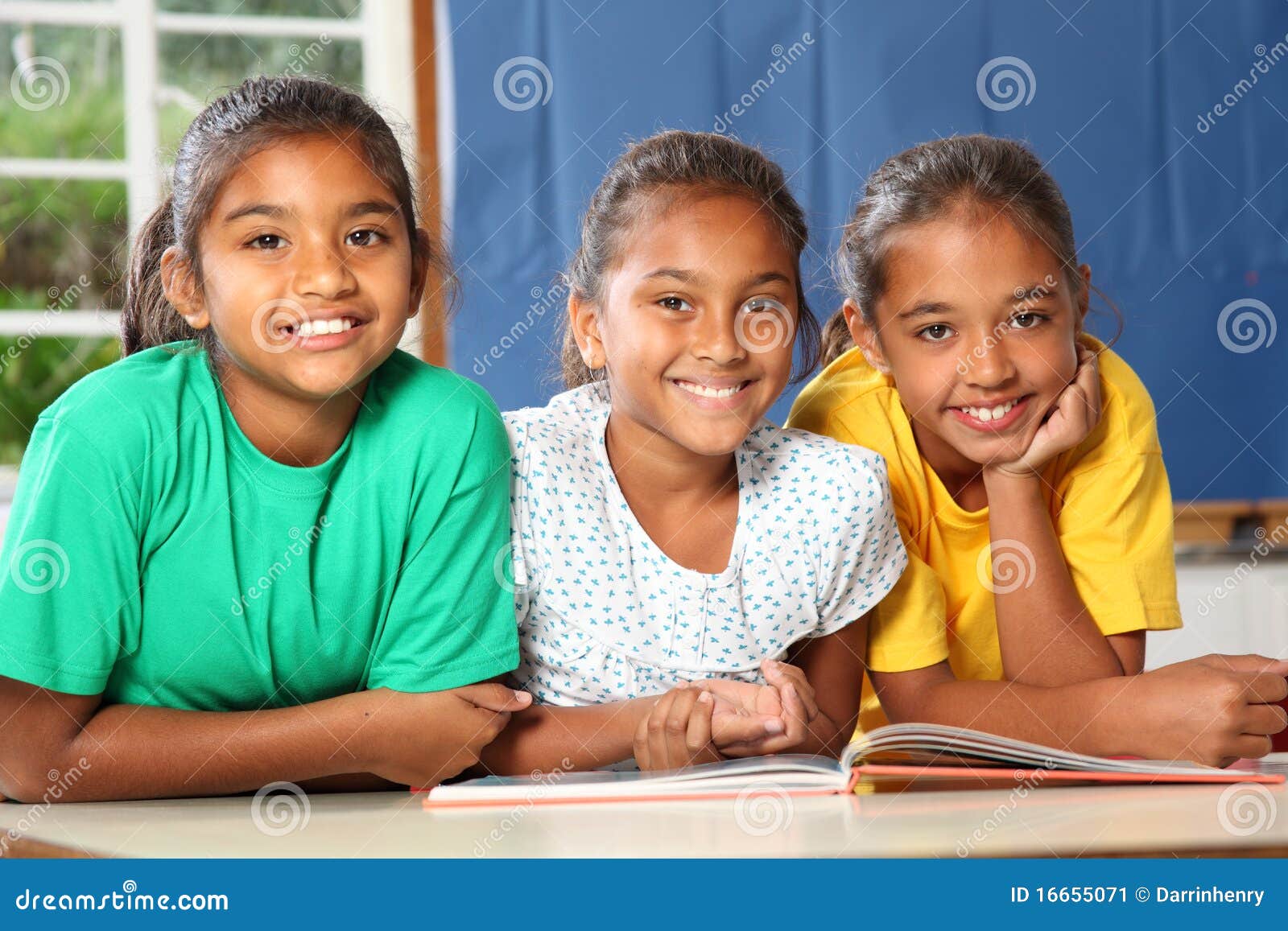 Three Happy School Girls Reading a Book in Class Stock Image - Image of ...