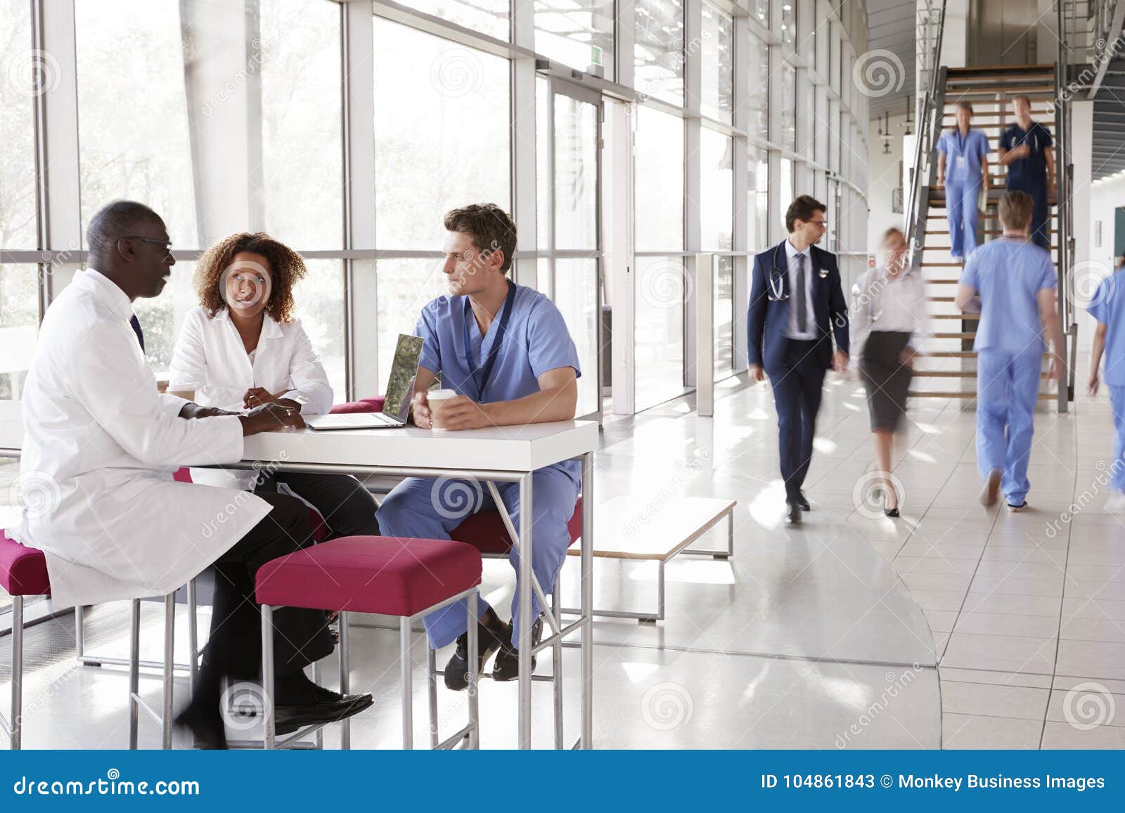 Three Healthcare Workers Talking in a Busy Modern Lobby Stock Image ...
