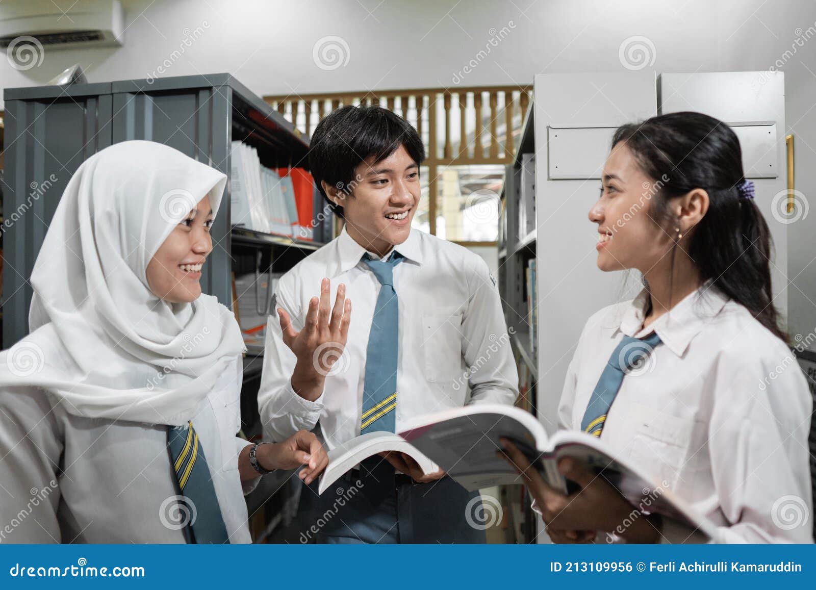 Three High School Students in Uniform Chatting while Reading Books ... Three High School Students in Uniform Chatting while Reading Books ...