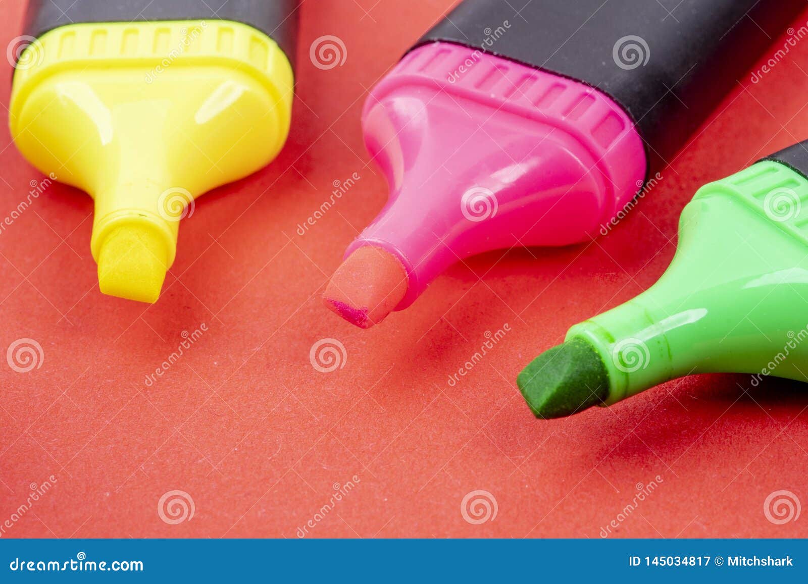 Three Highlighters in Yellow Pink and Green on a Red Background Stock ...