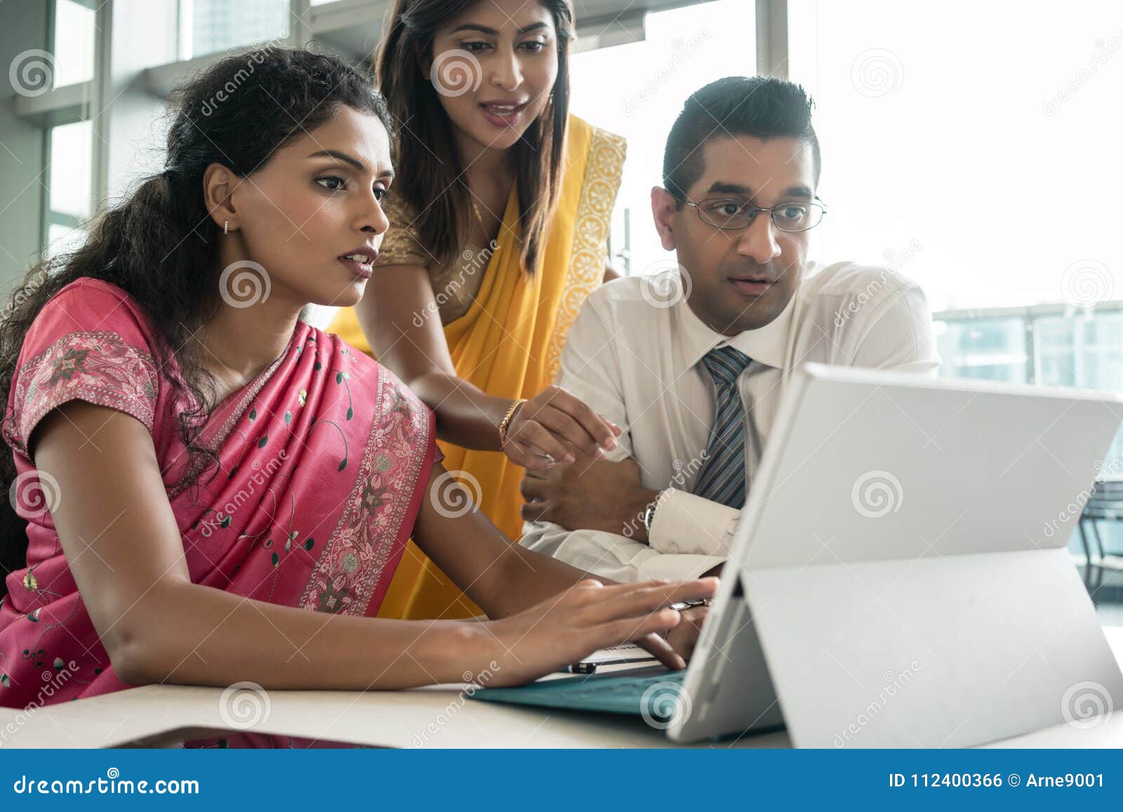 Three Indian Employees Working Together Around a Laptop Stock Photo ... Three Indian Employees Working Together Around a Laptop Stock Photo ...